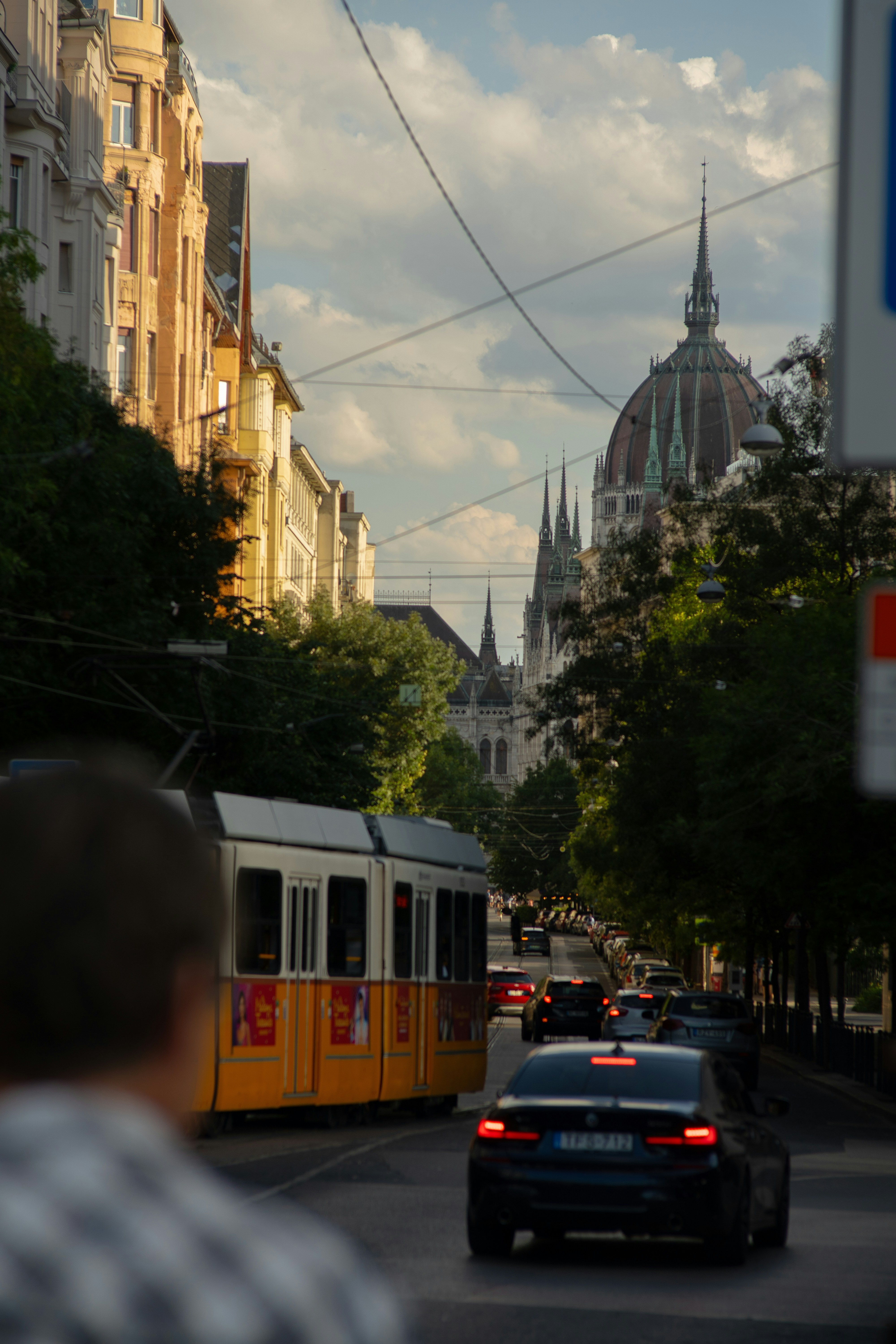 Hungarian parliament | A tram travels through a city street.