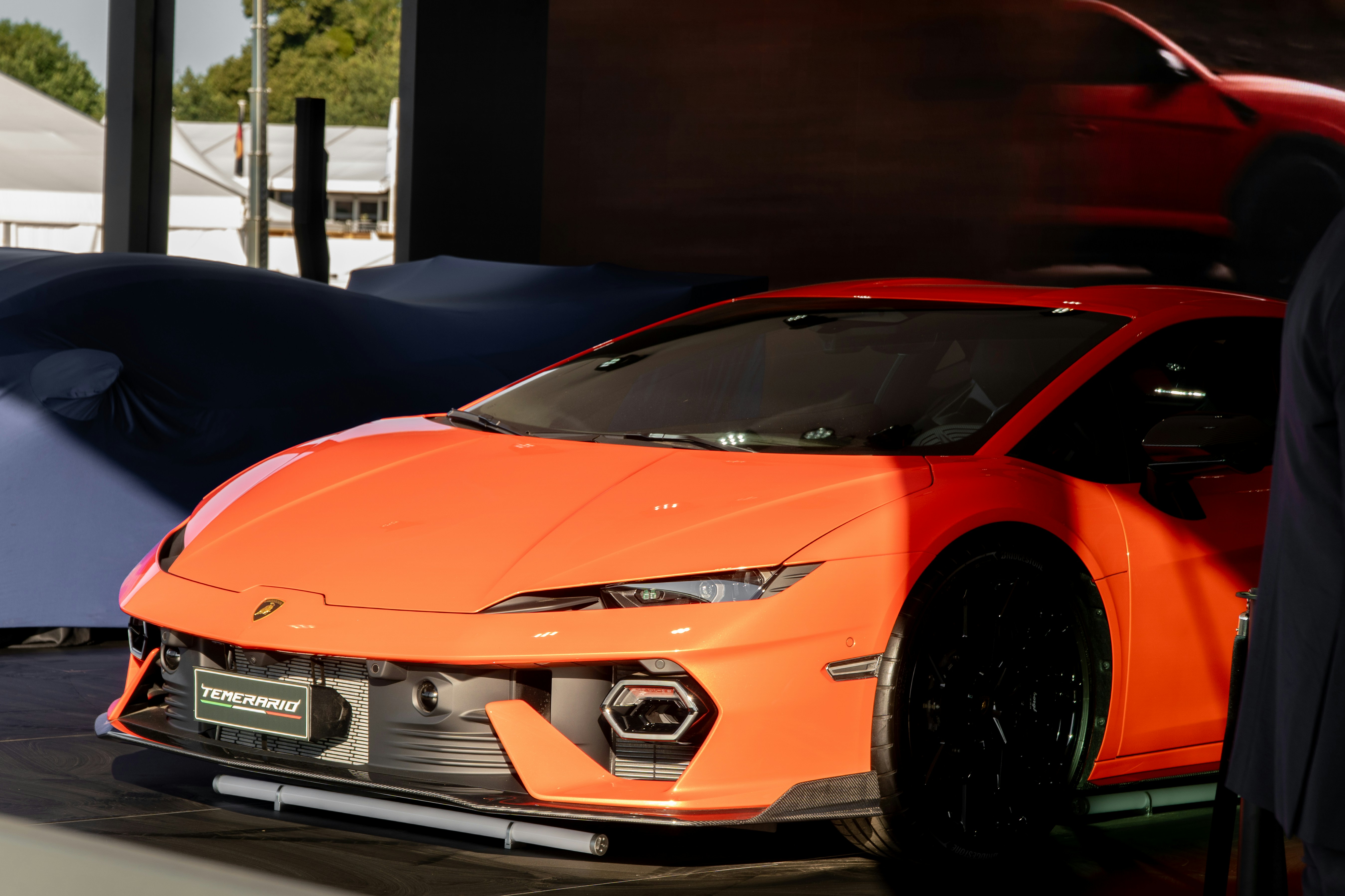An orange lamborghini is on display.
