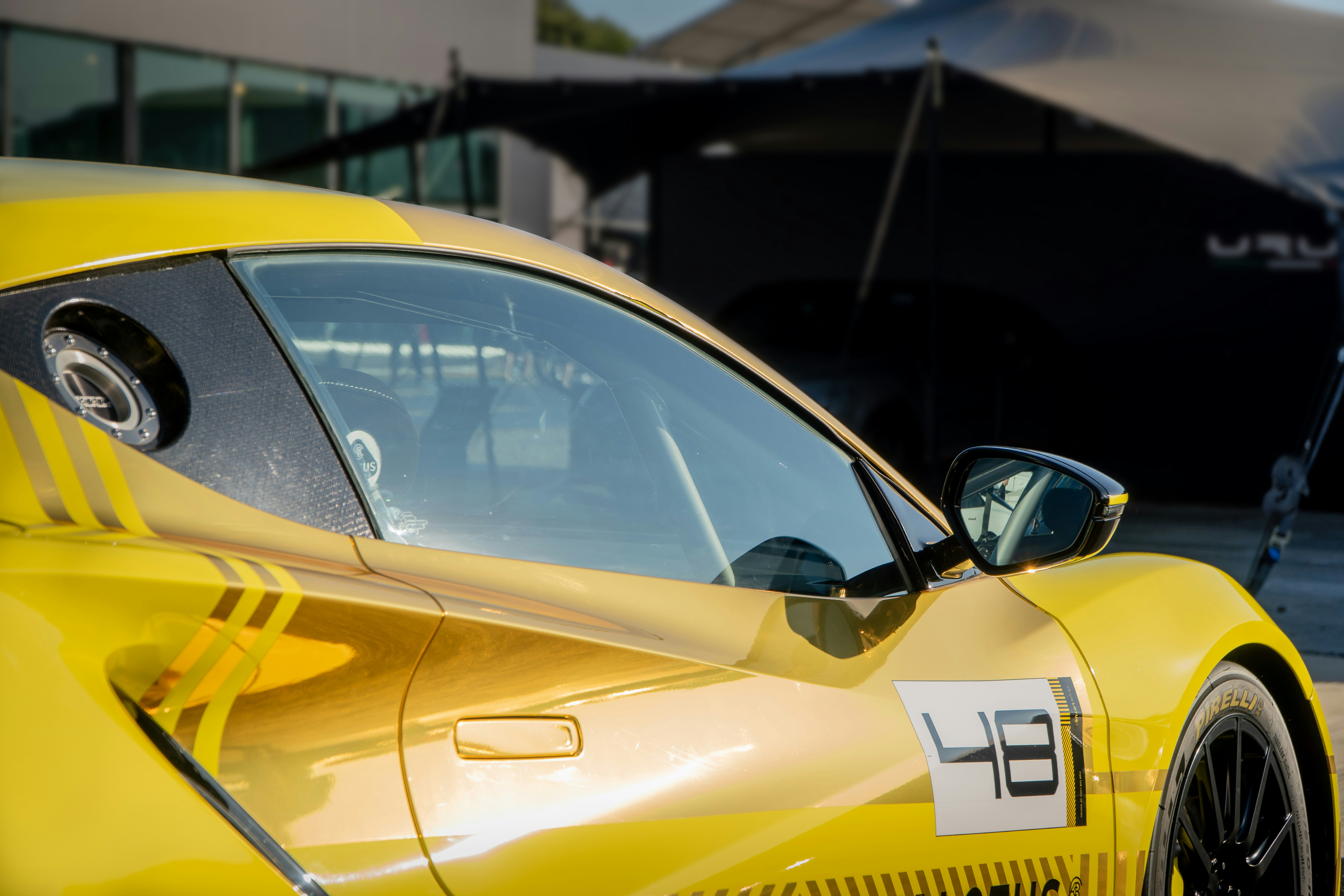 A bright yellow race car is seen in detail.