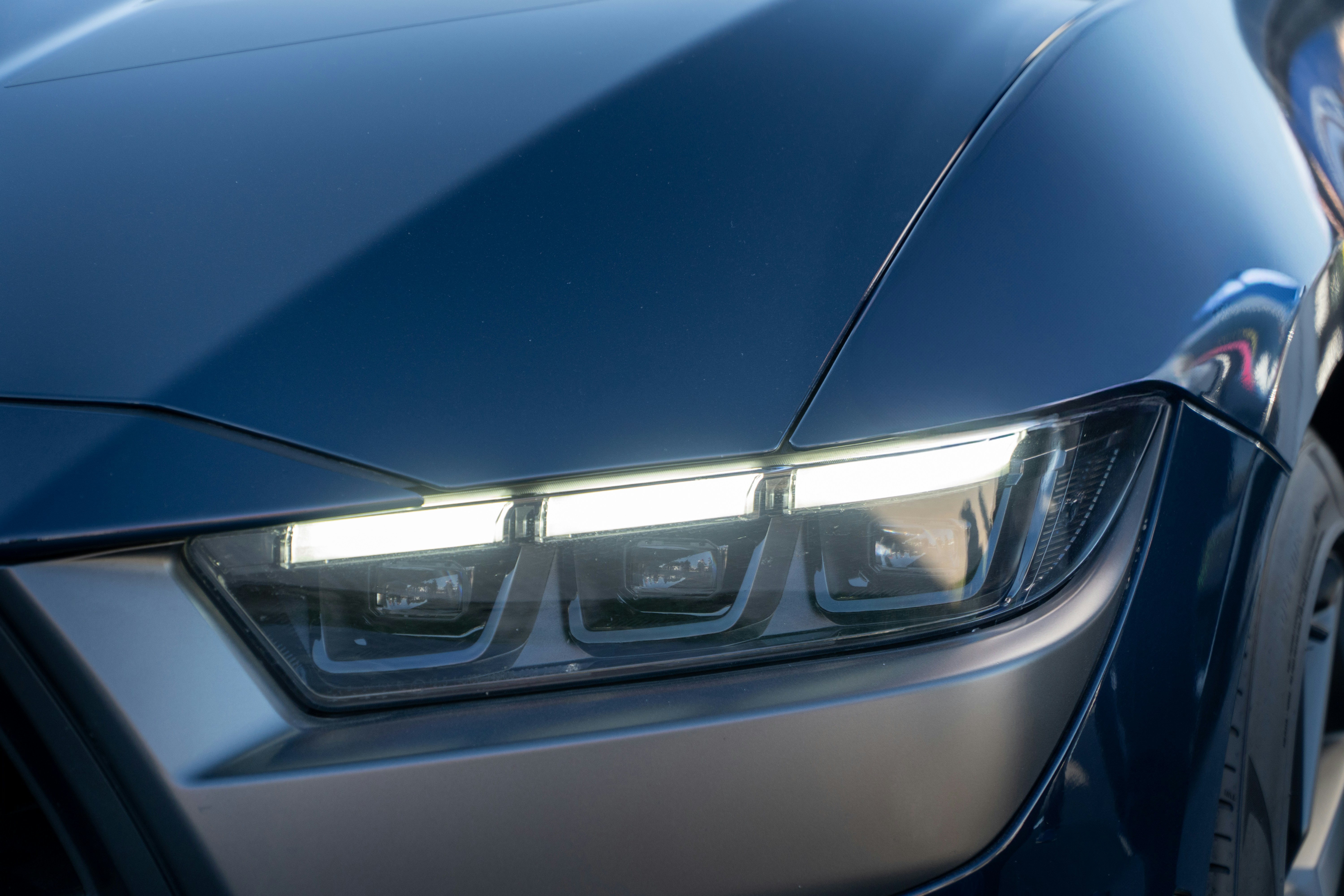 A close-up shows a car's headlight.