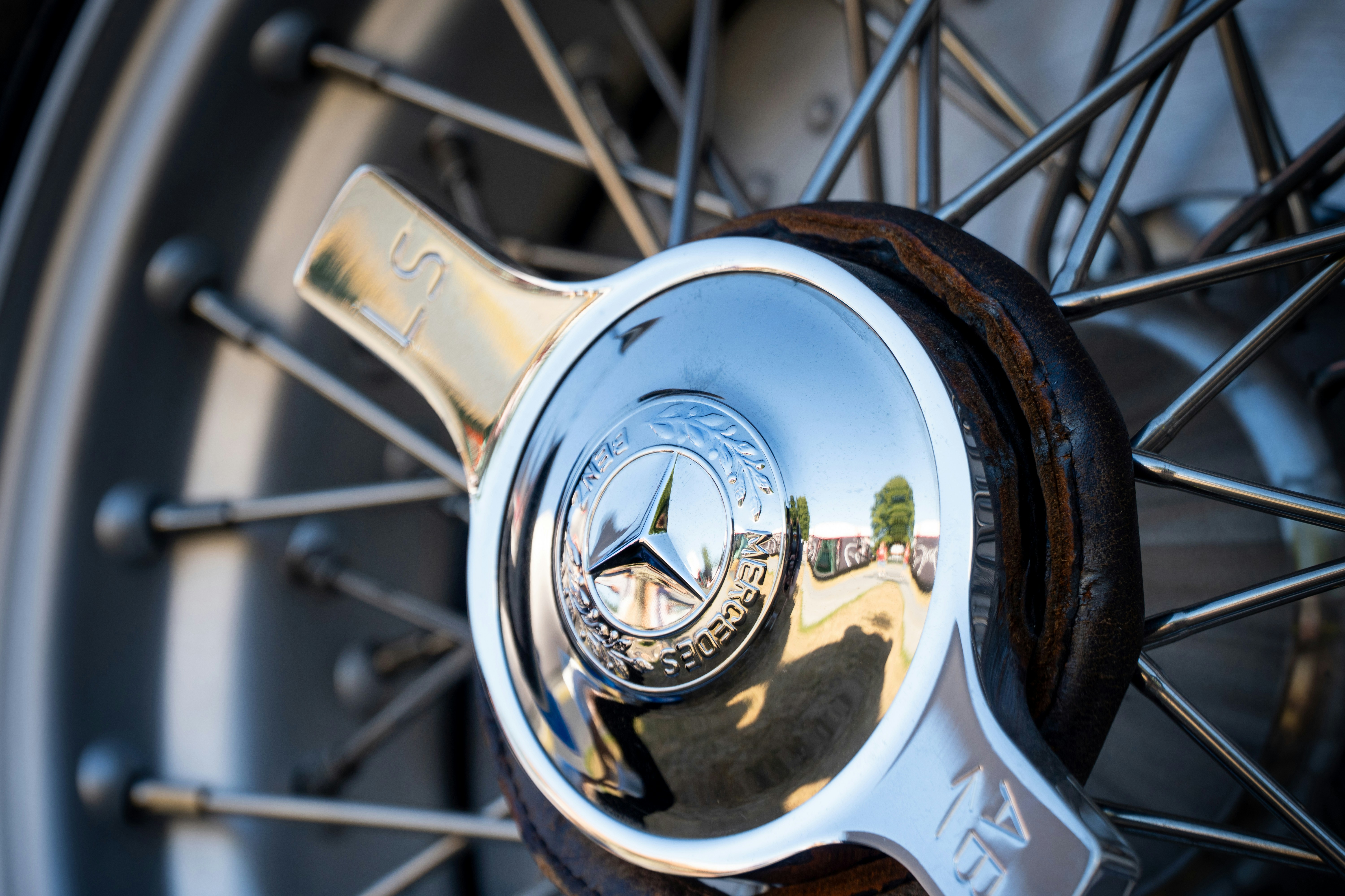 A close-up shows a shiny mercedes wheel.