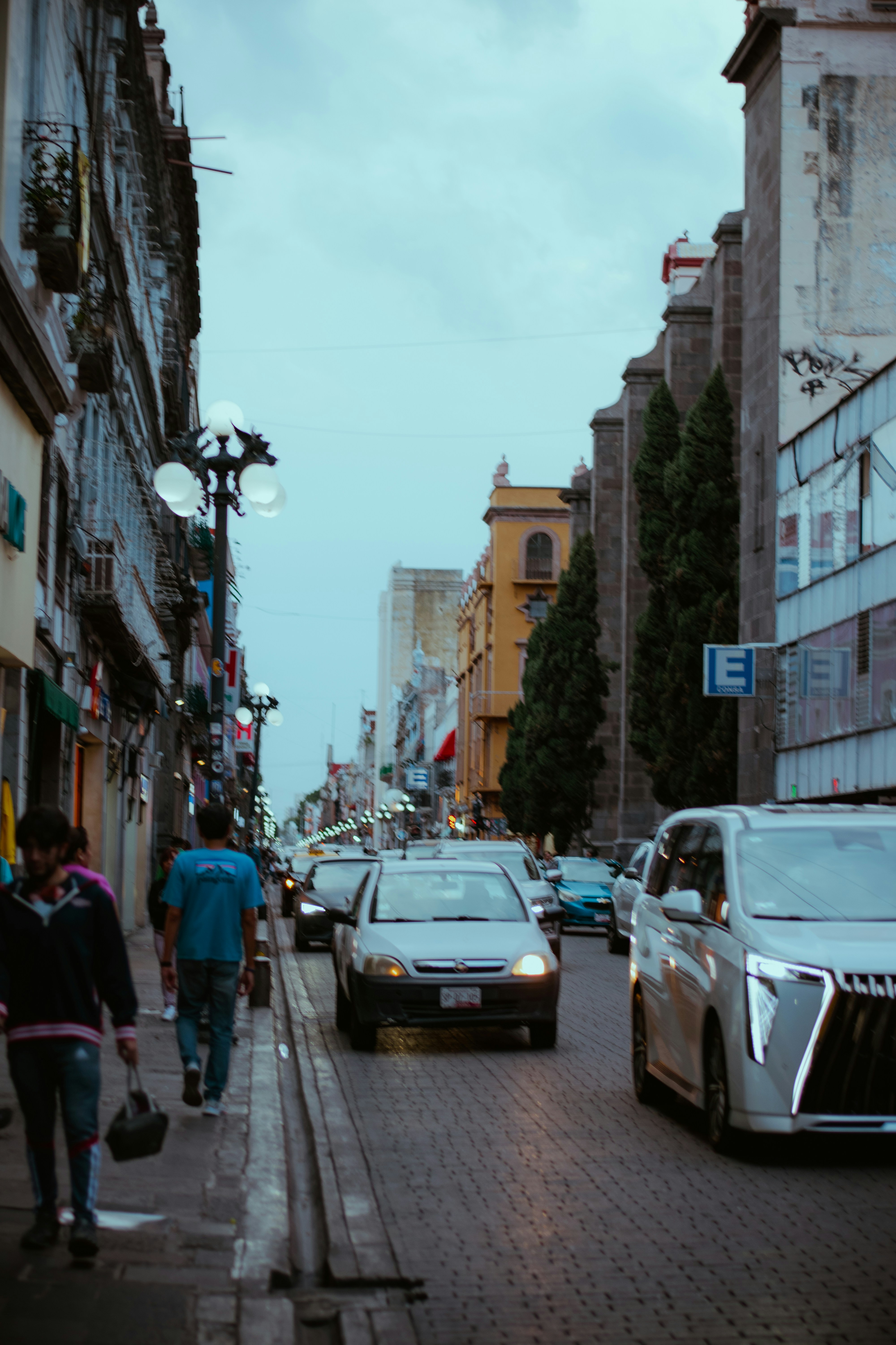Street scene with cars and pedestrians in an urban area.