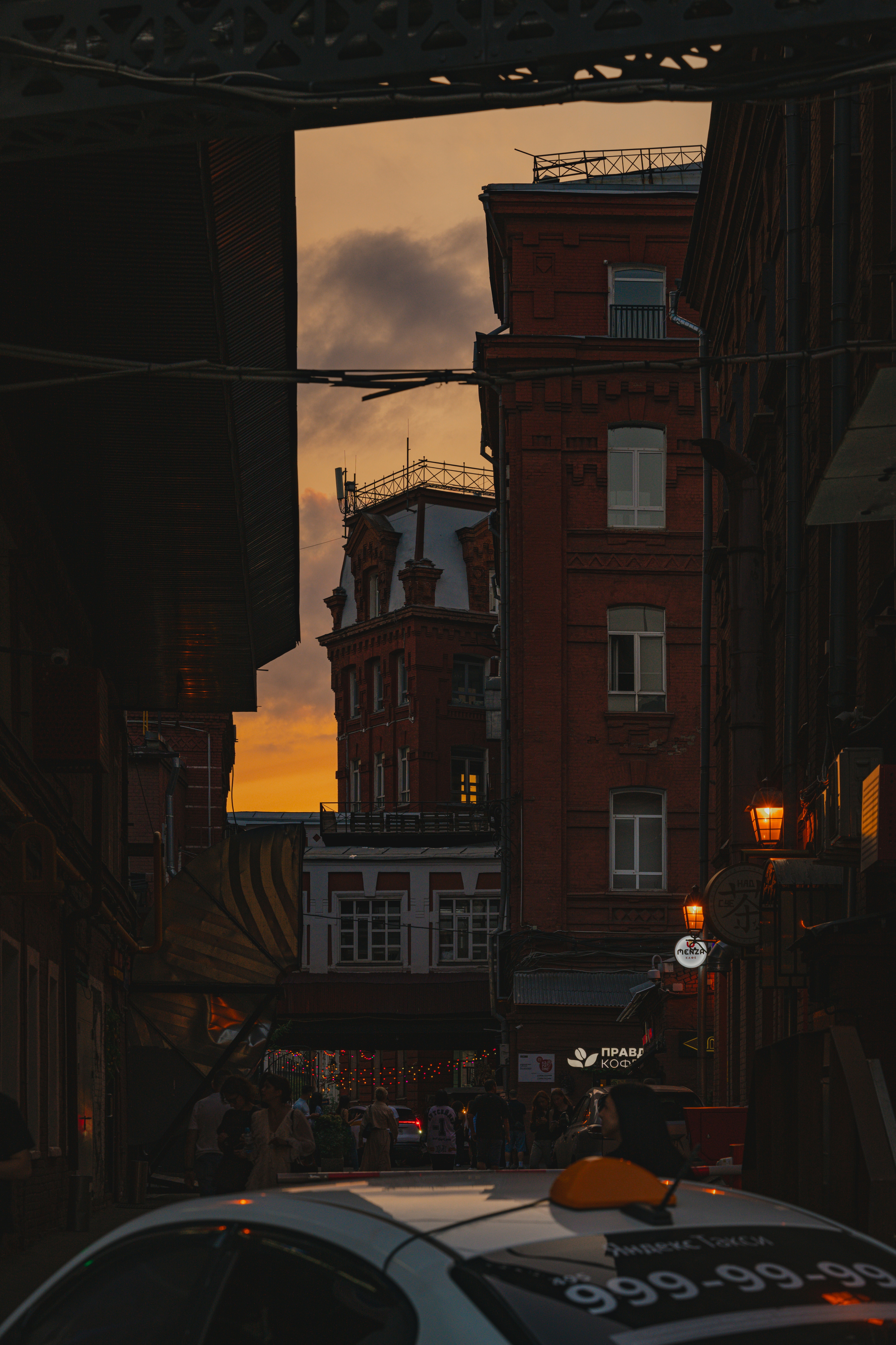 Buildings frame a sunset over the city street.