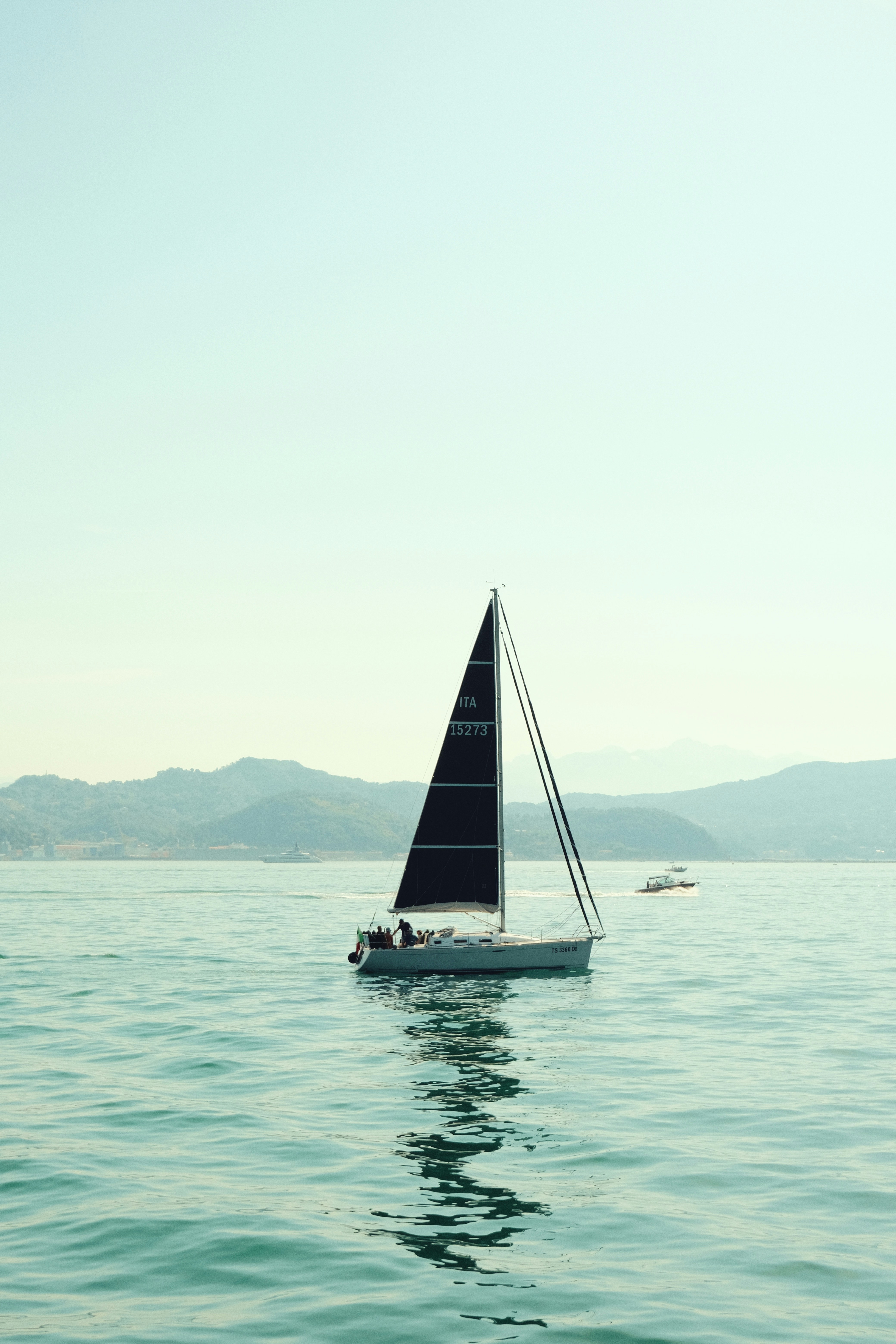 Liguria , barca a vela | A sailboat peacefully glides on the calm ocean.