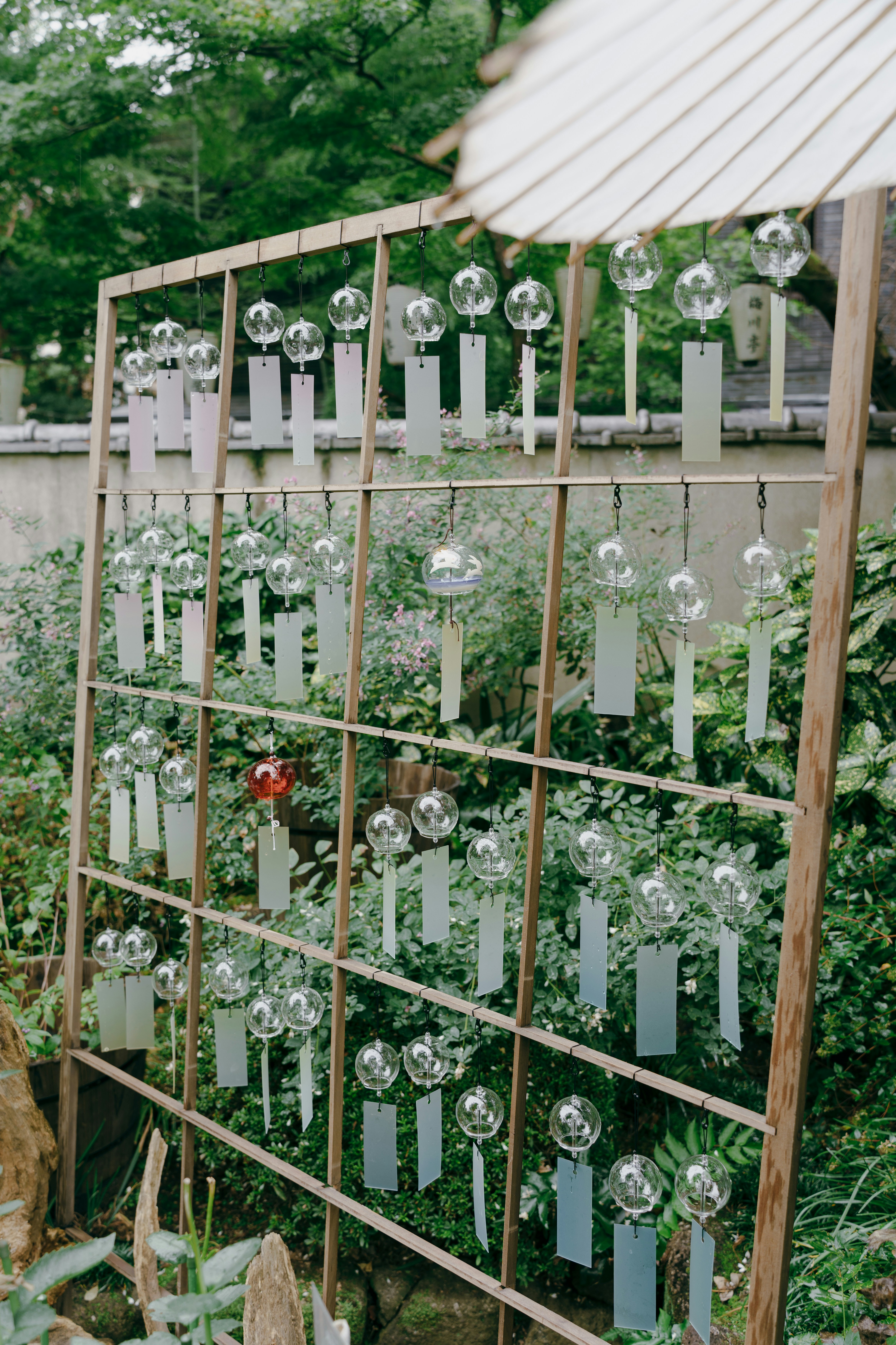 Wind chimes hang in a garden.