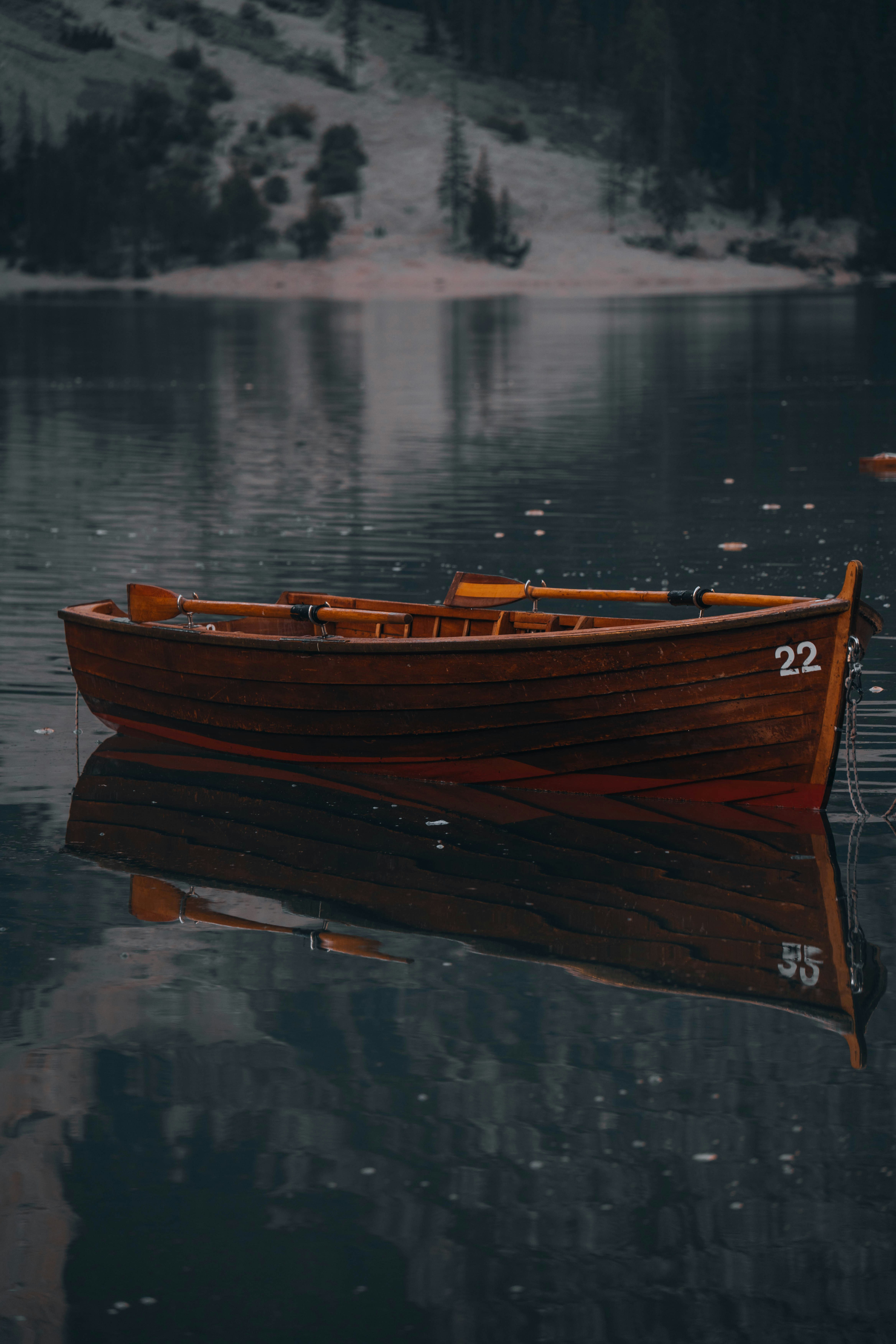A wooden boat reflects calmly on the water.