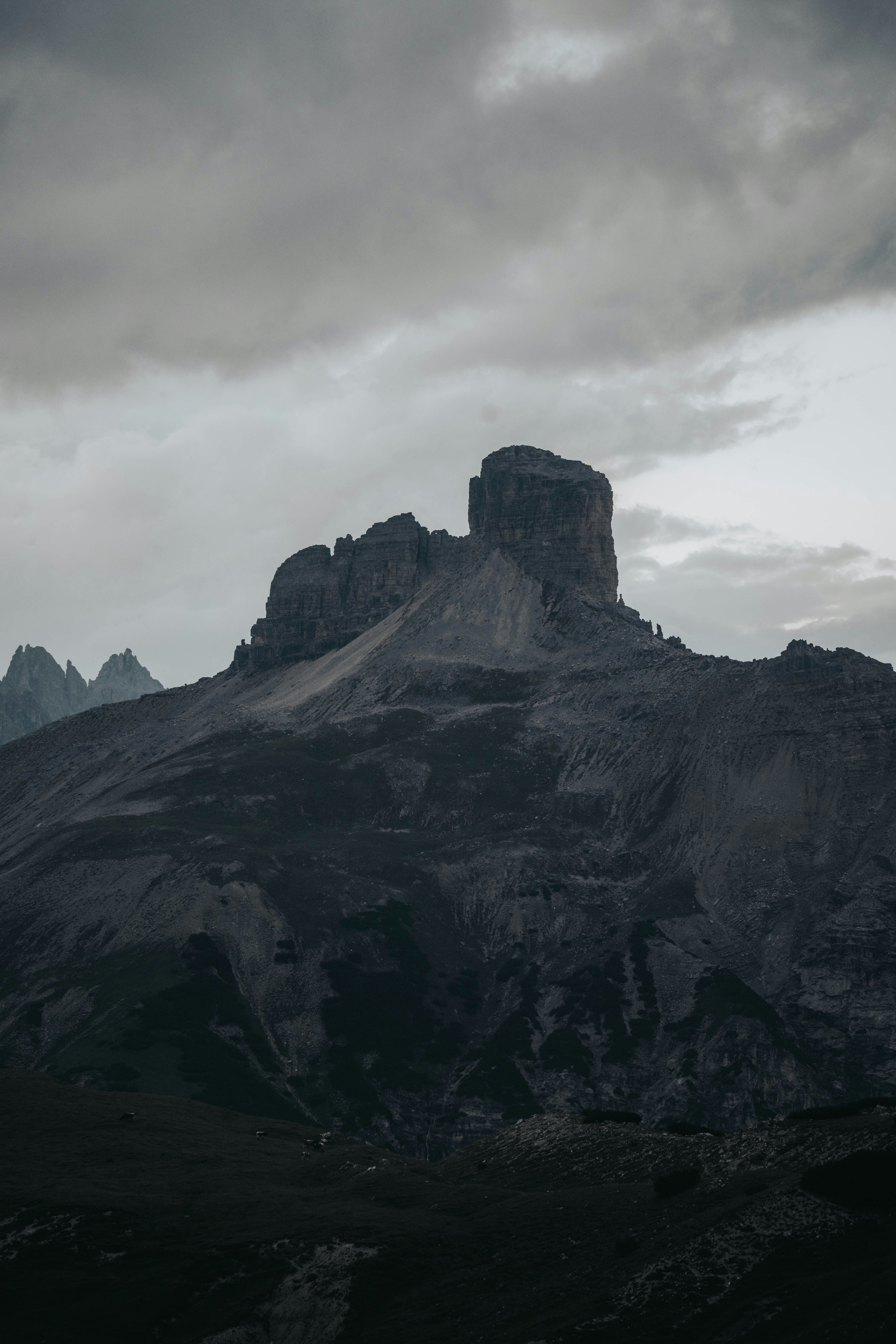 Majestic mountain peak rising dramatically against a moody sky, showcasing the rugged beauty of the Dolomites.