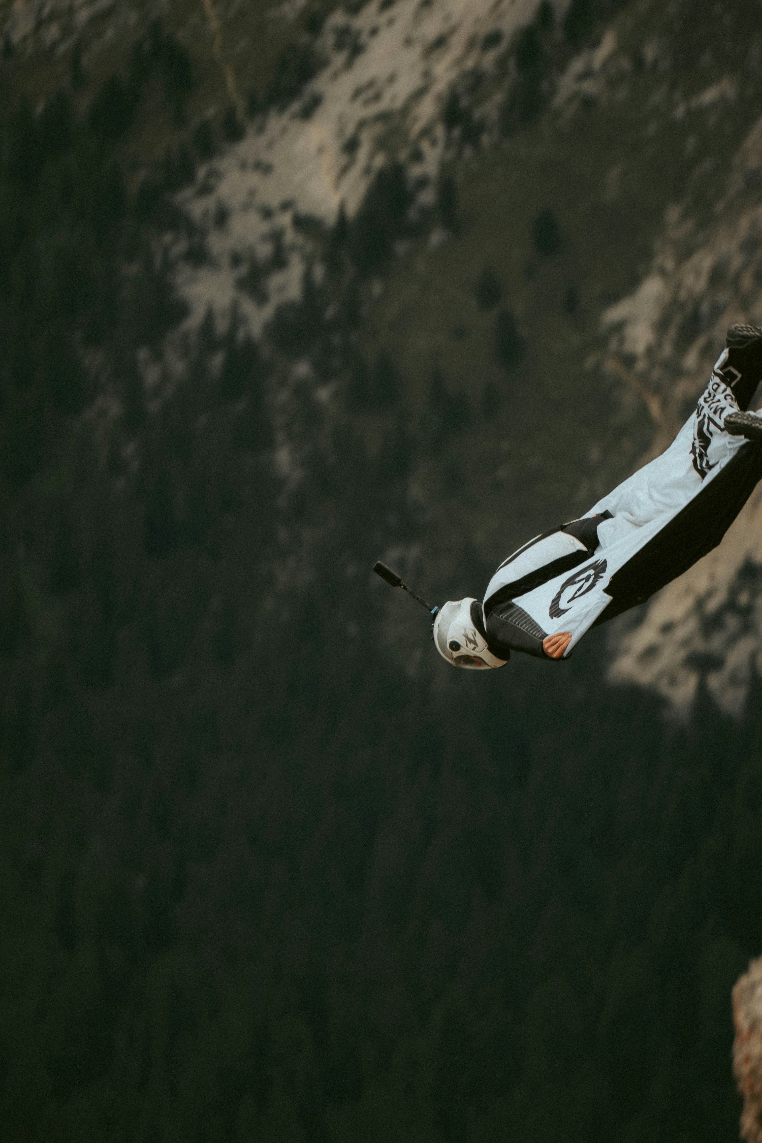 A skydiver soars off a cliff.