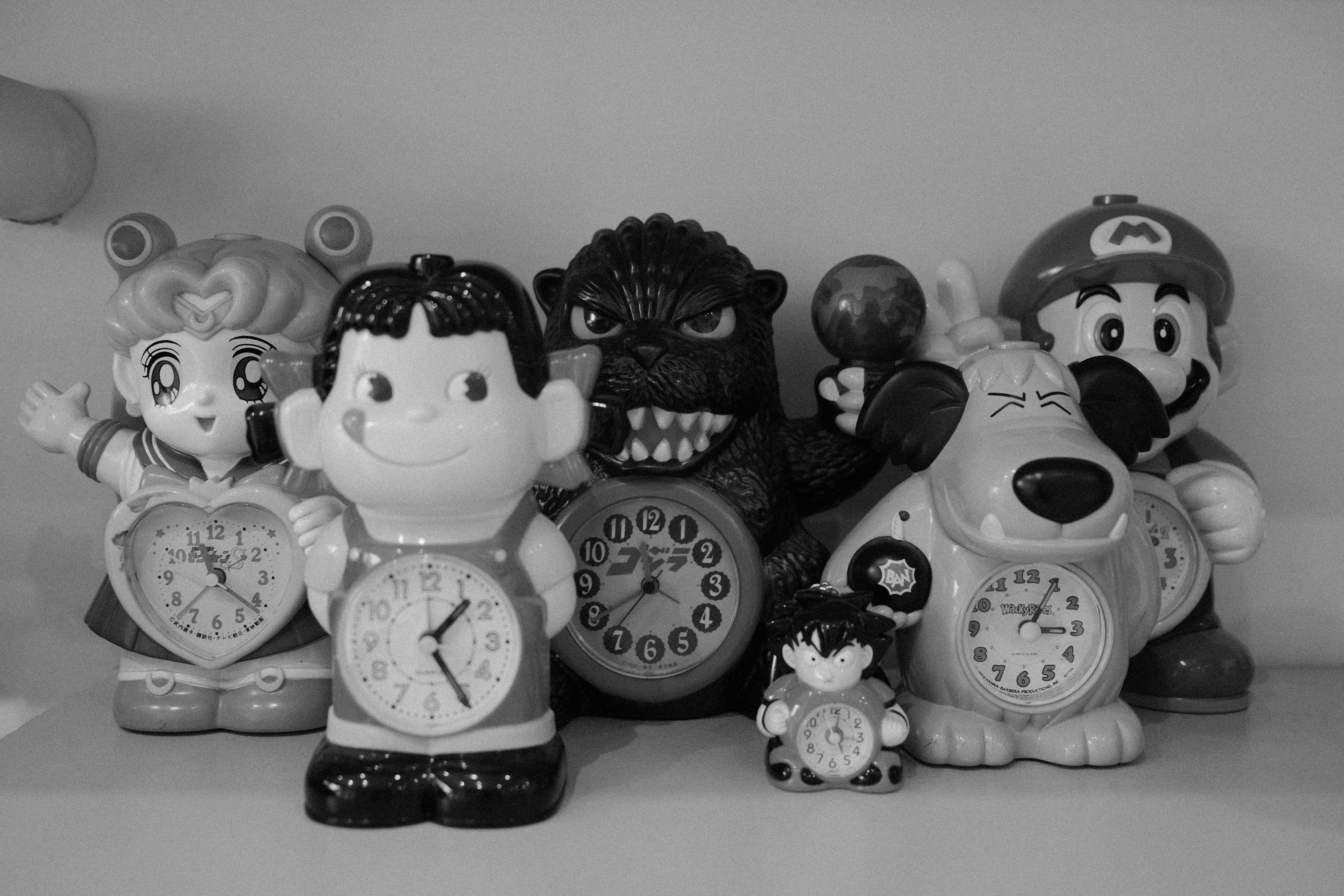 Alarm clocks featuring various cartoon characters sit together. photo ...