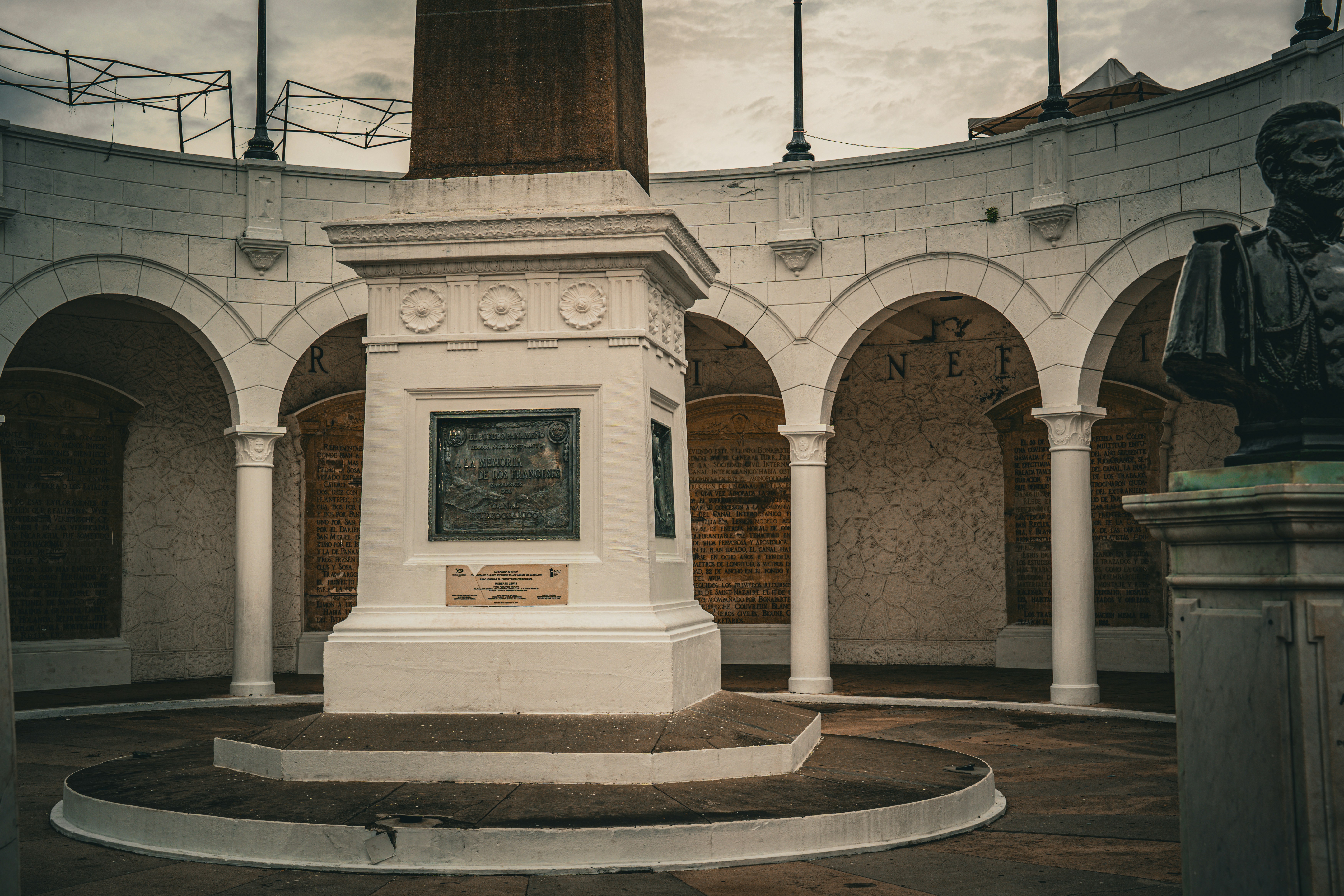 A monument stands in a curved colonnade.
