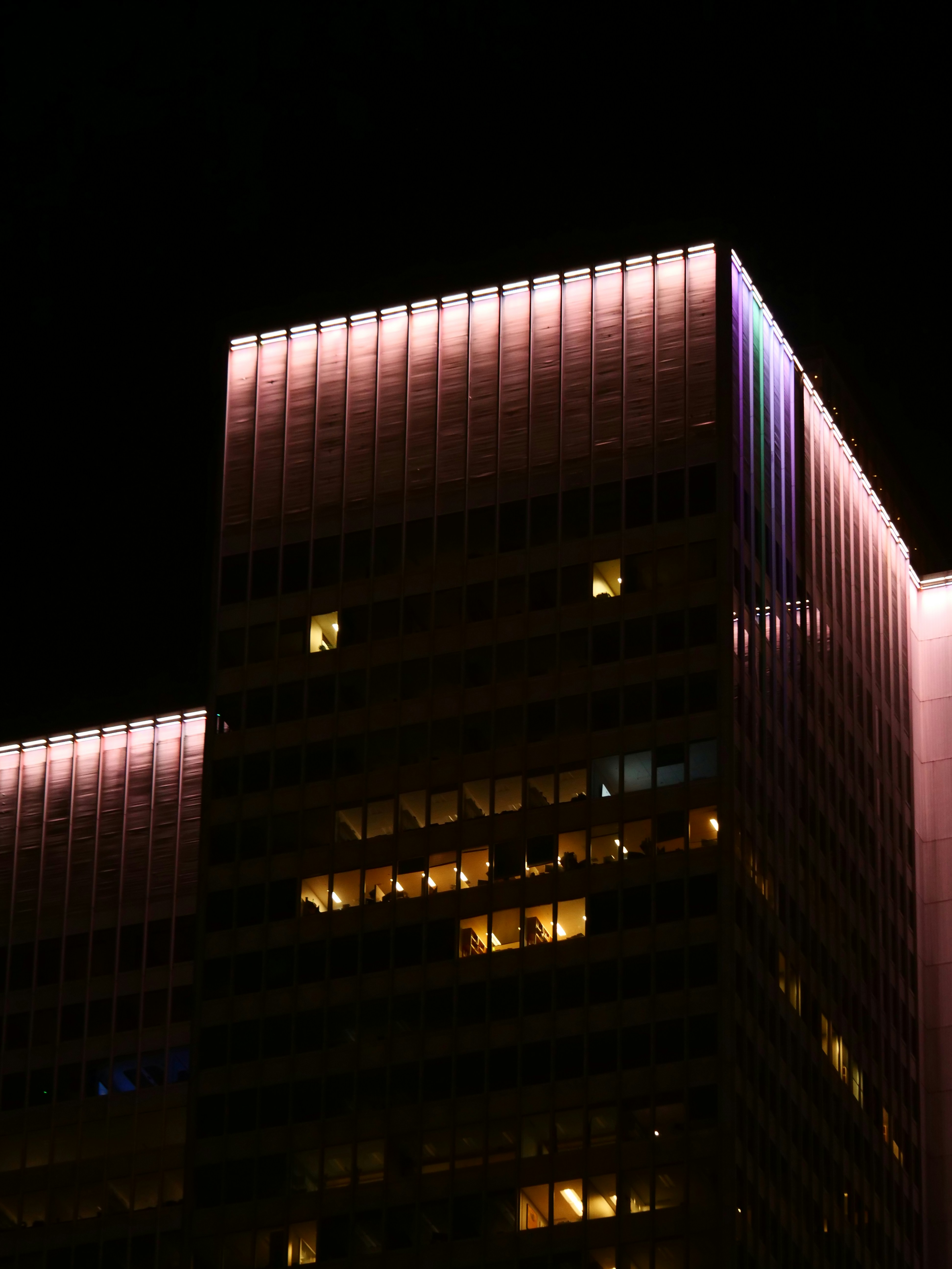 A tall building glows at night.