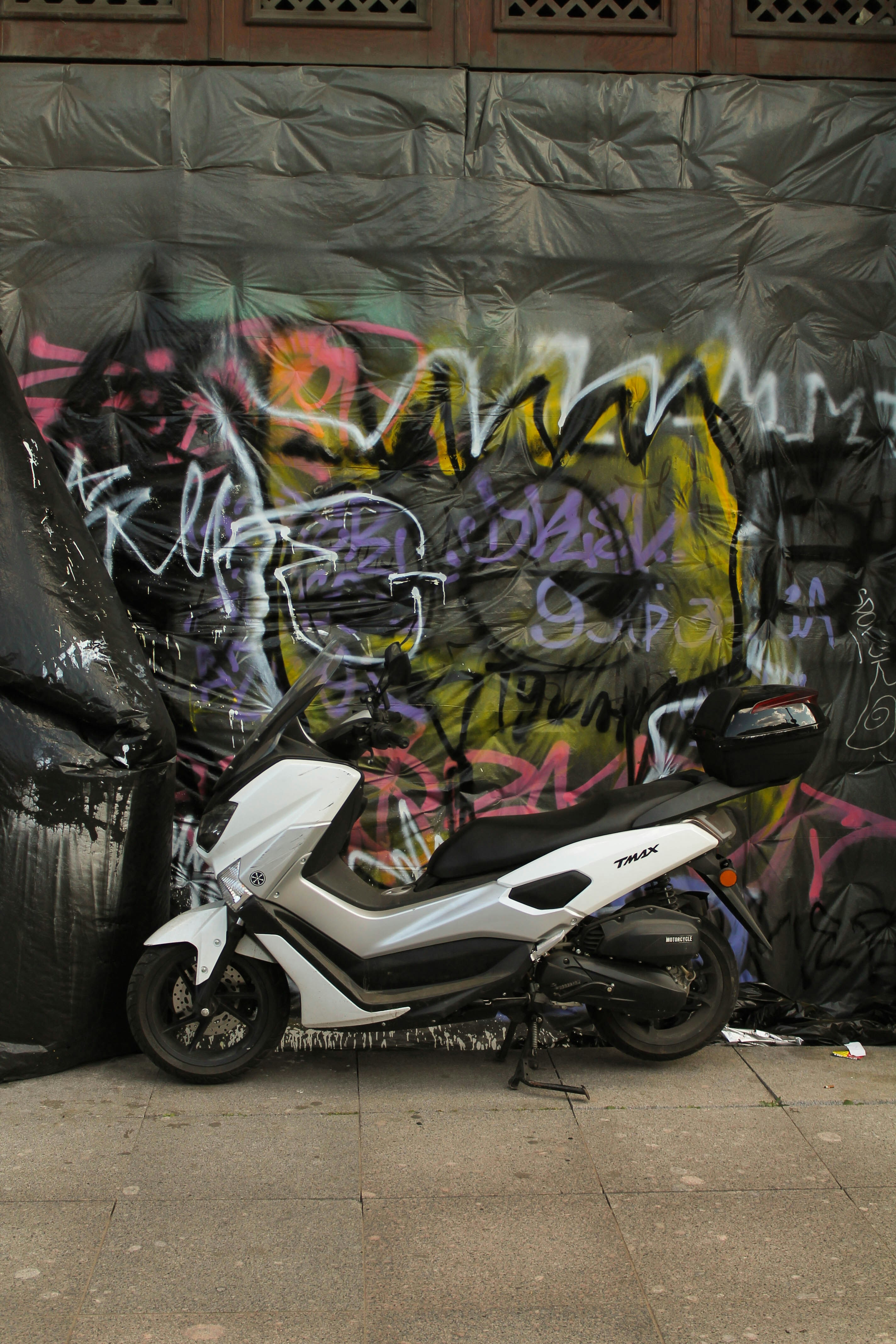 A white scooter is parked in front of graffiti. photo – Free Art Image ...