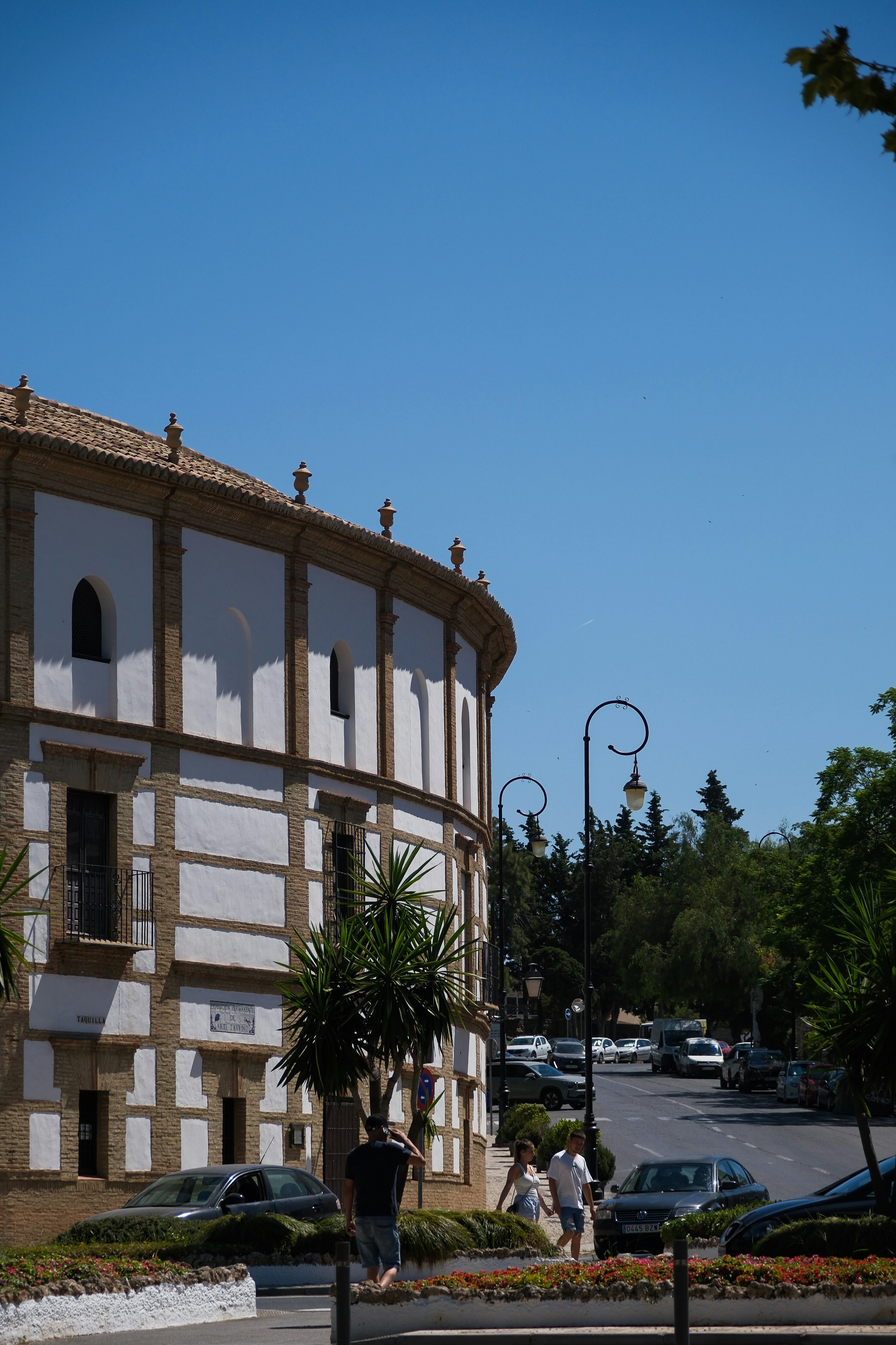 A circular building and a street under a blue sky.