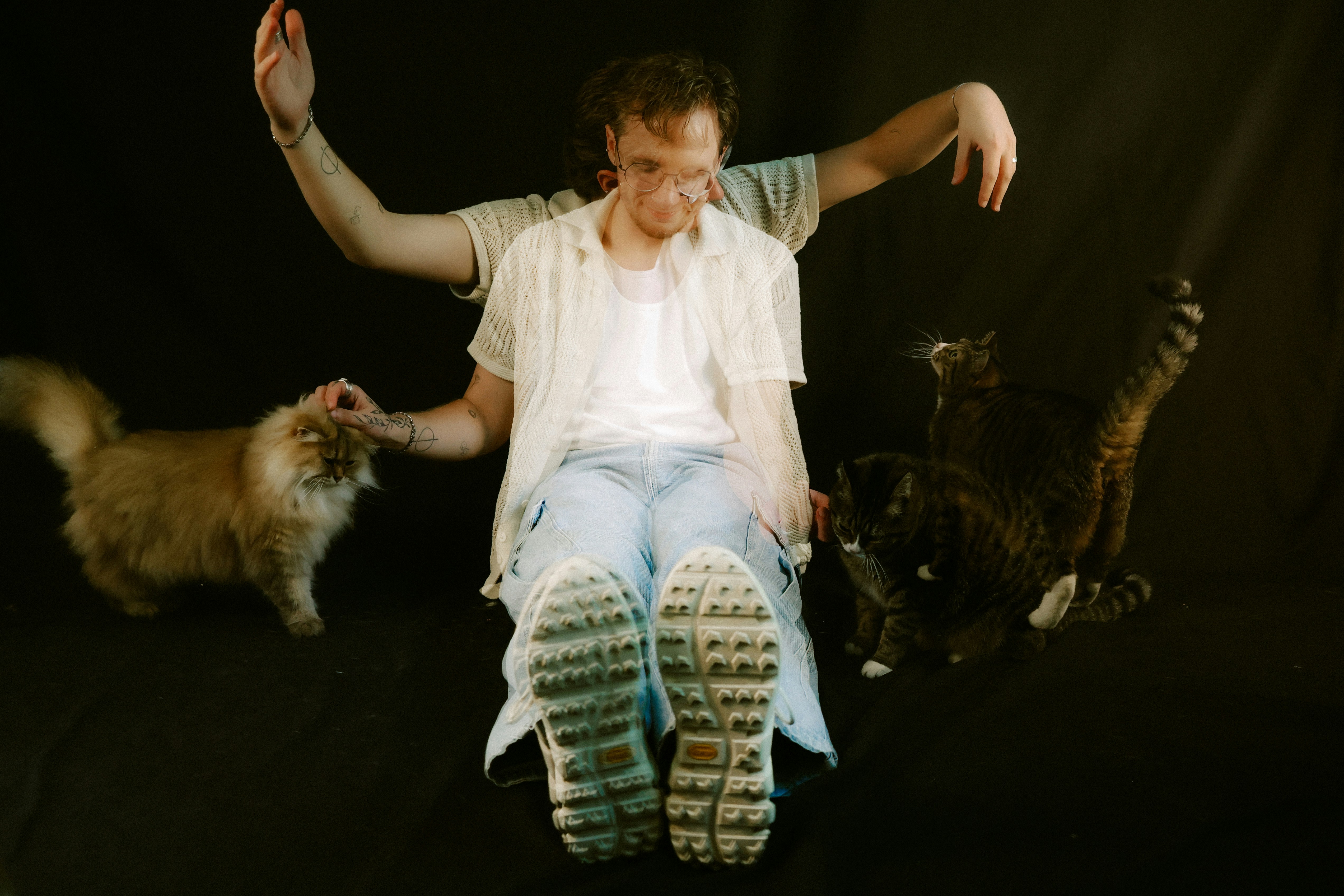 Midair Jester: A man in denim and white shirt surrounded by friendly pets