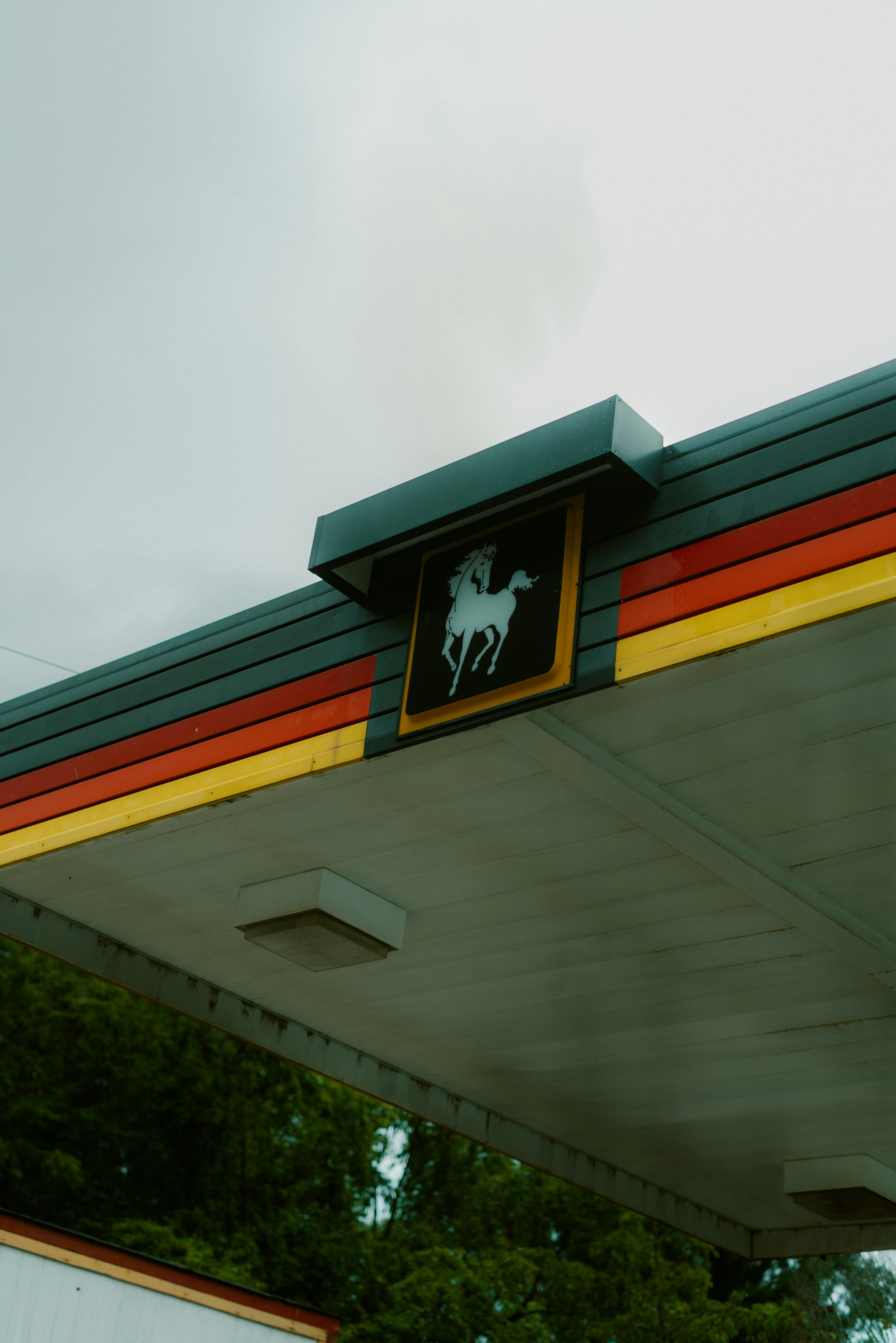 An old gas station canopy with a logo.