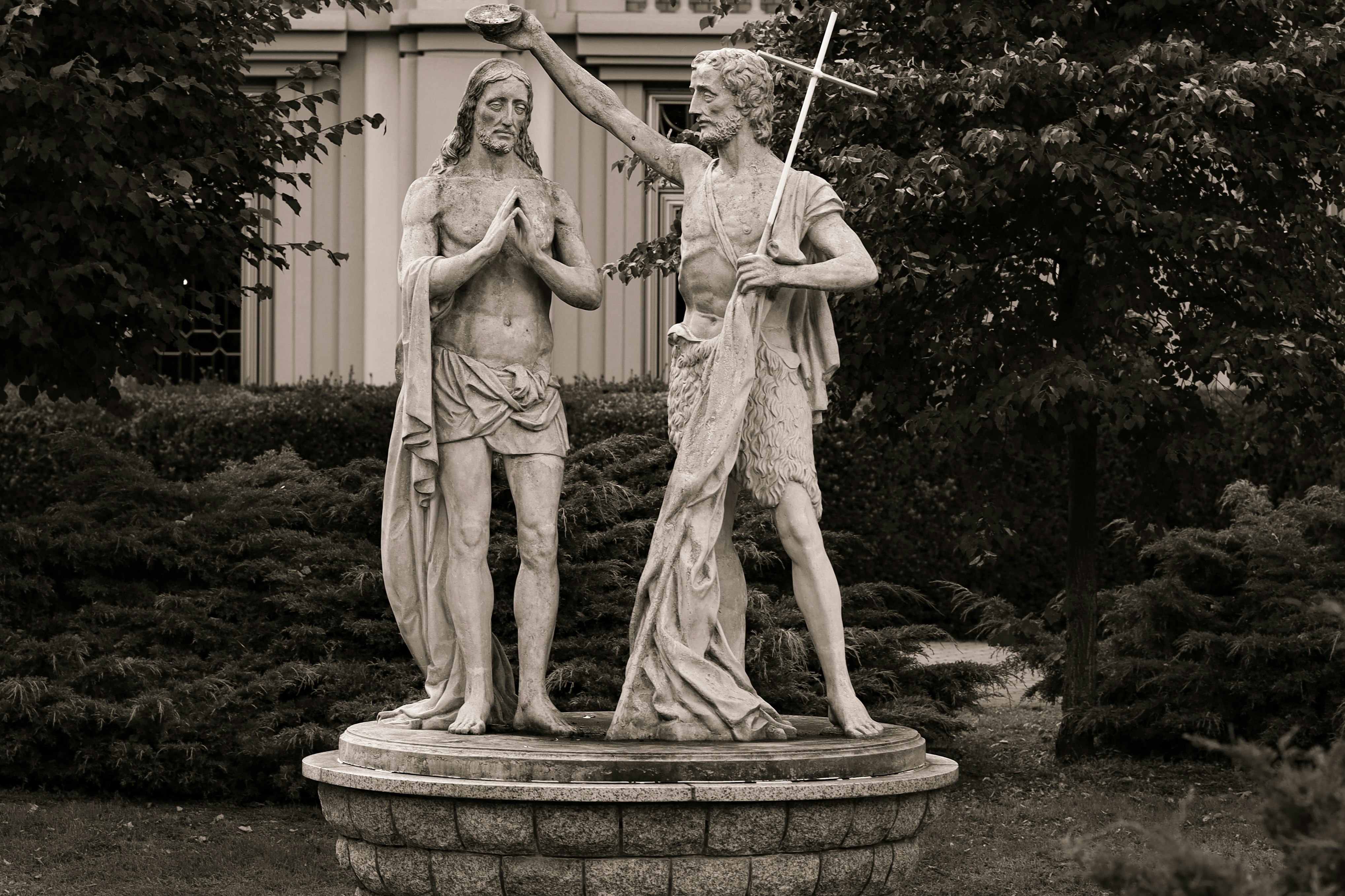 Statue depicts jesus being baptized by john.
