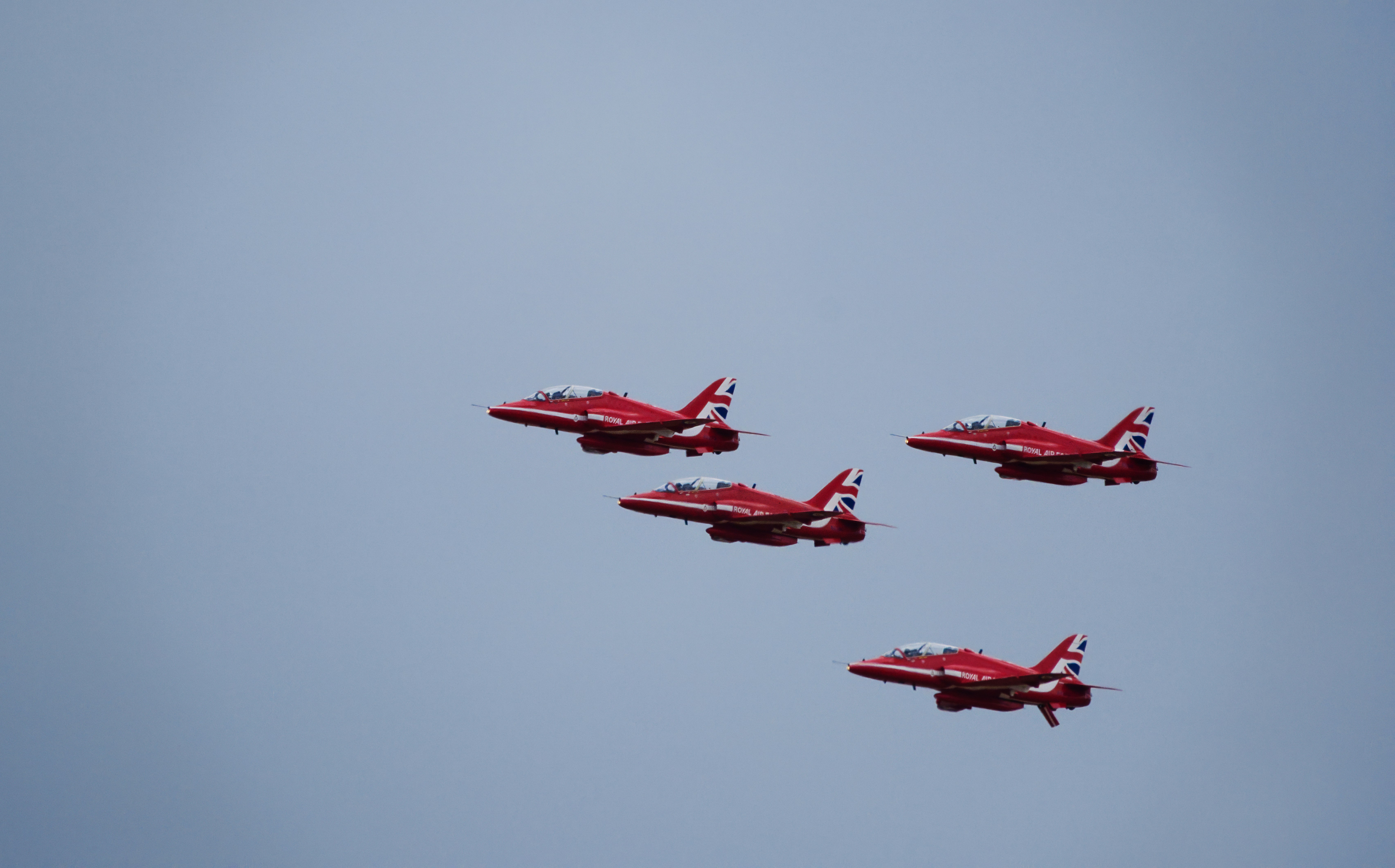 Red Arrows at RIAT 2025 | Four red arrows perform in the sky.