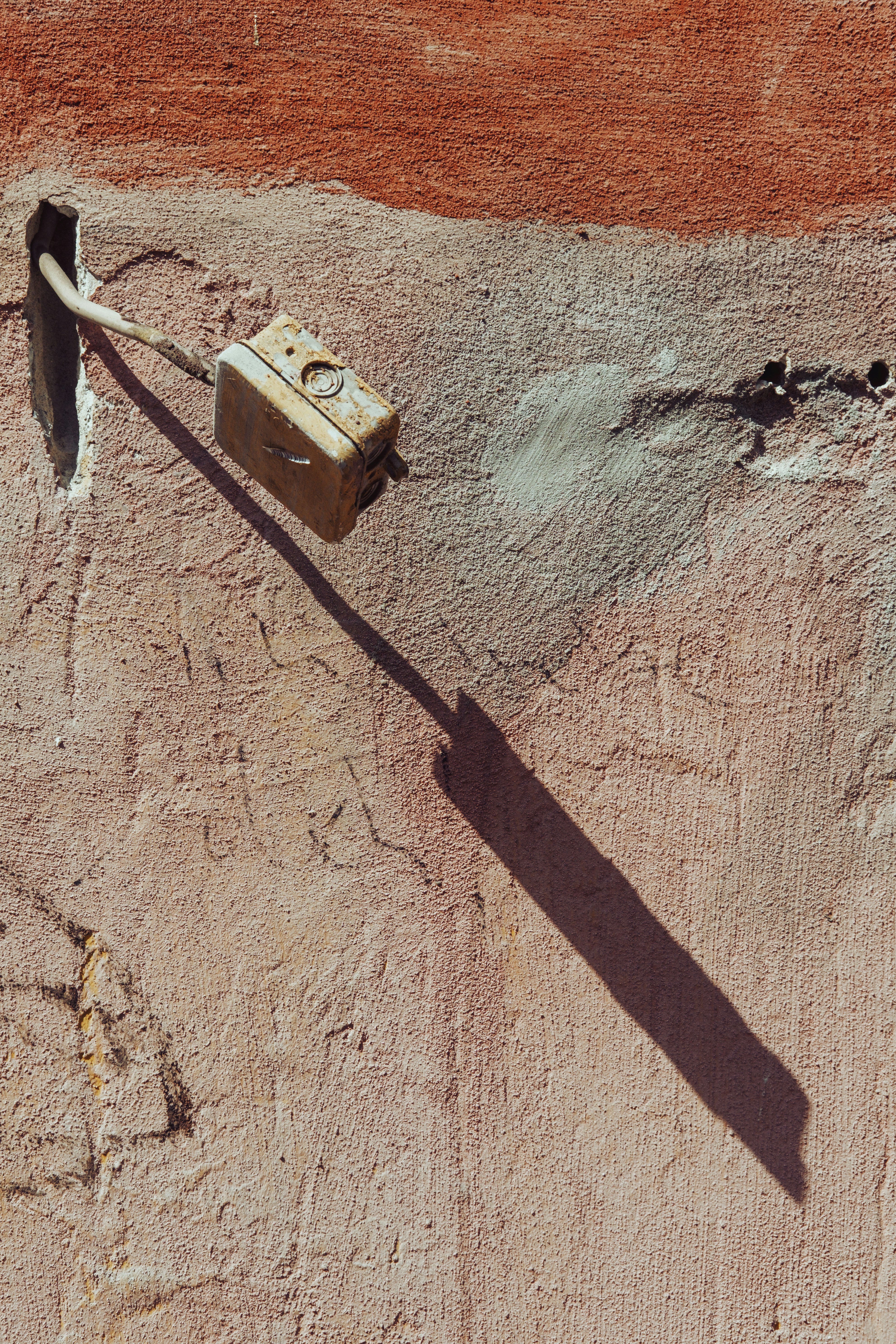 Old electrical box casting a long shadow.