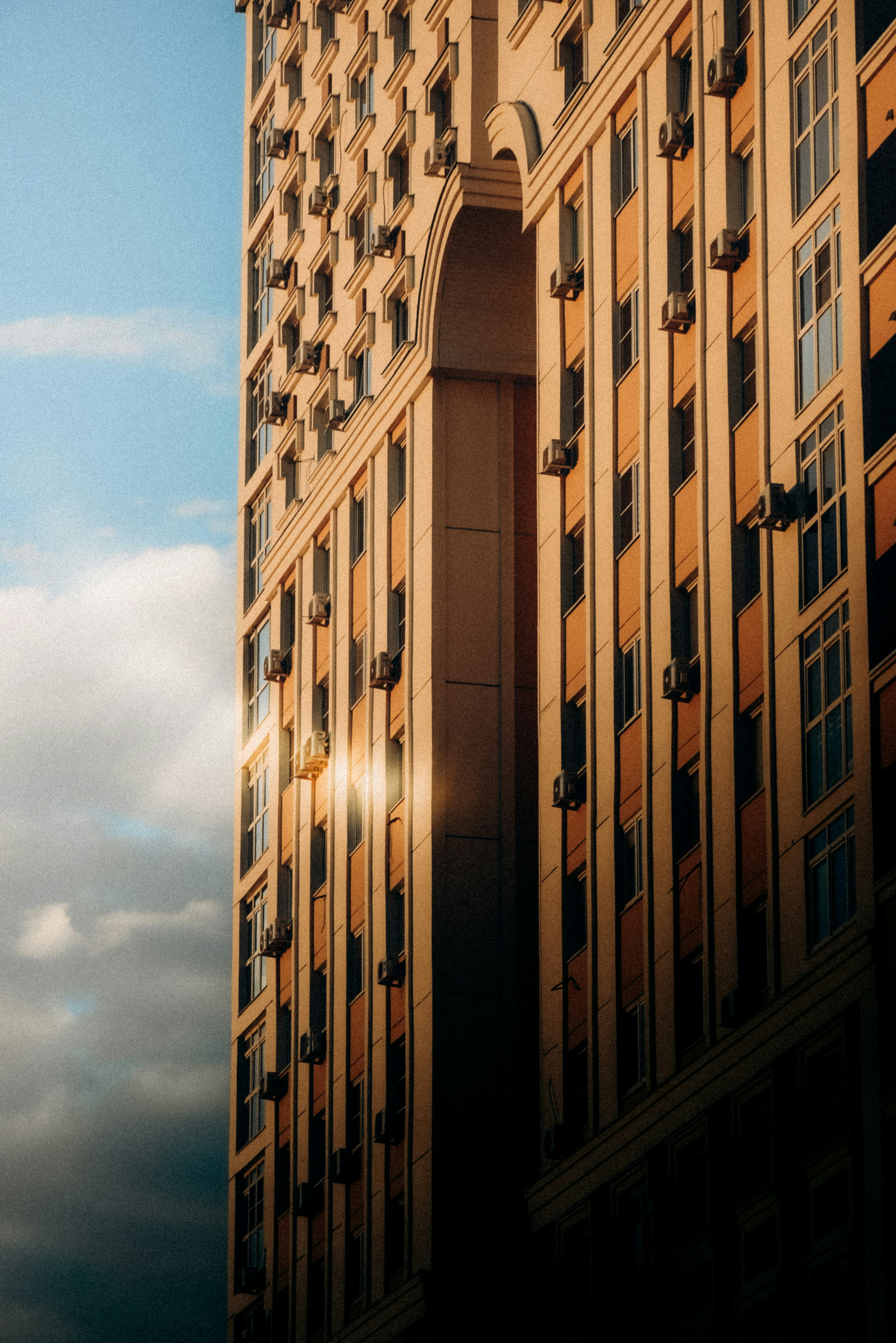 A tall building with sunlight reflecting off its facade.