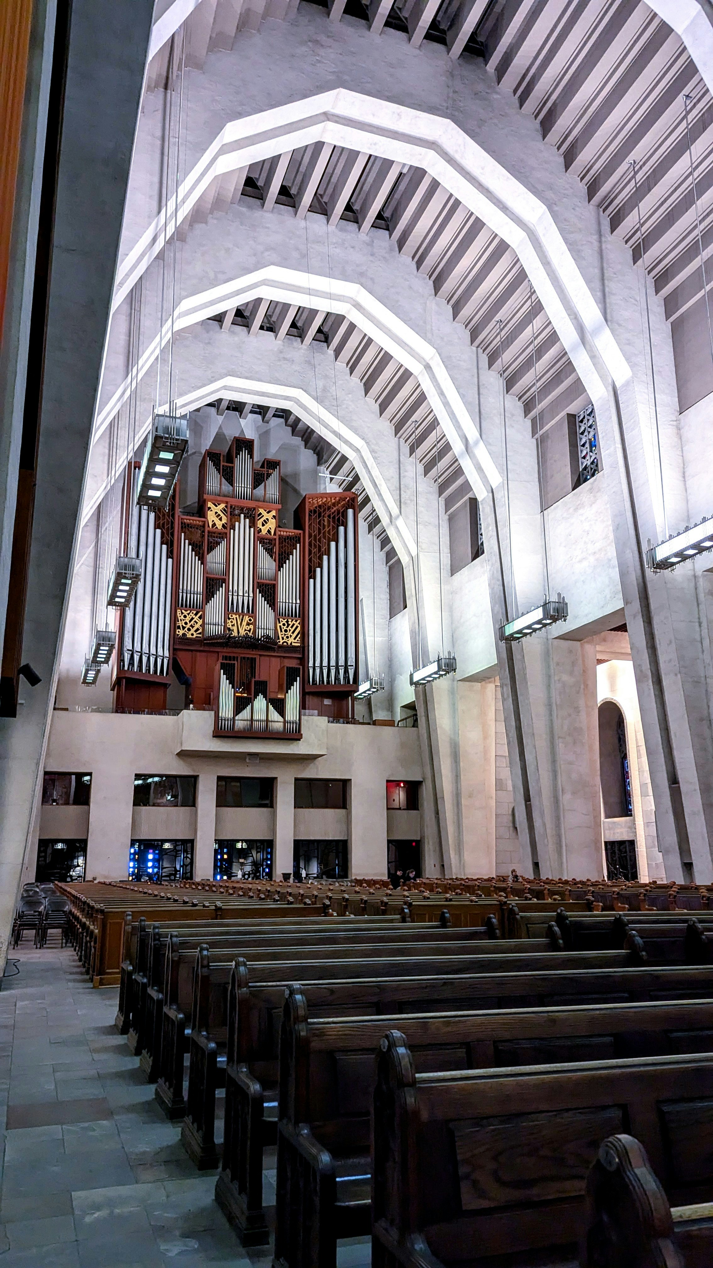 Inside a cathedral, featuring an organ and pews.
