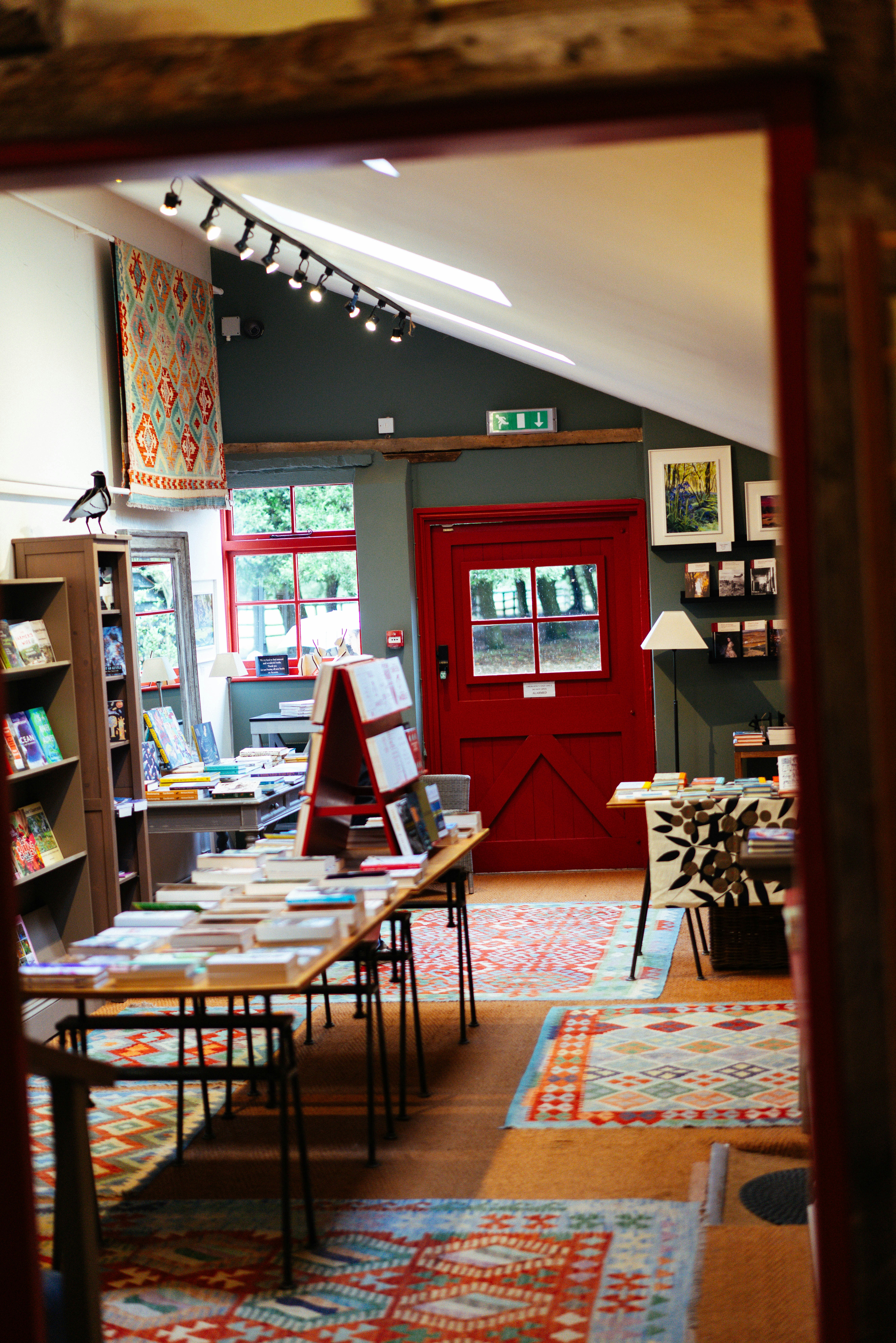 A cozy bookstore interior with books, rugs, and red door. photo – Free ...