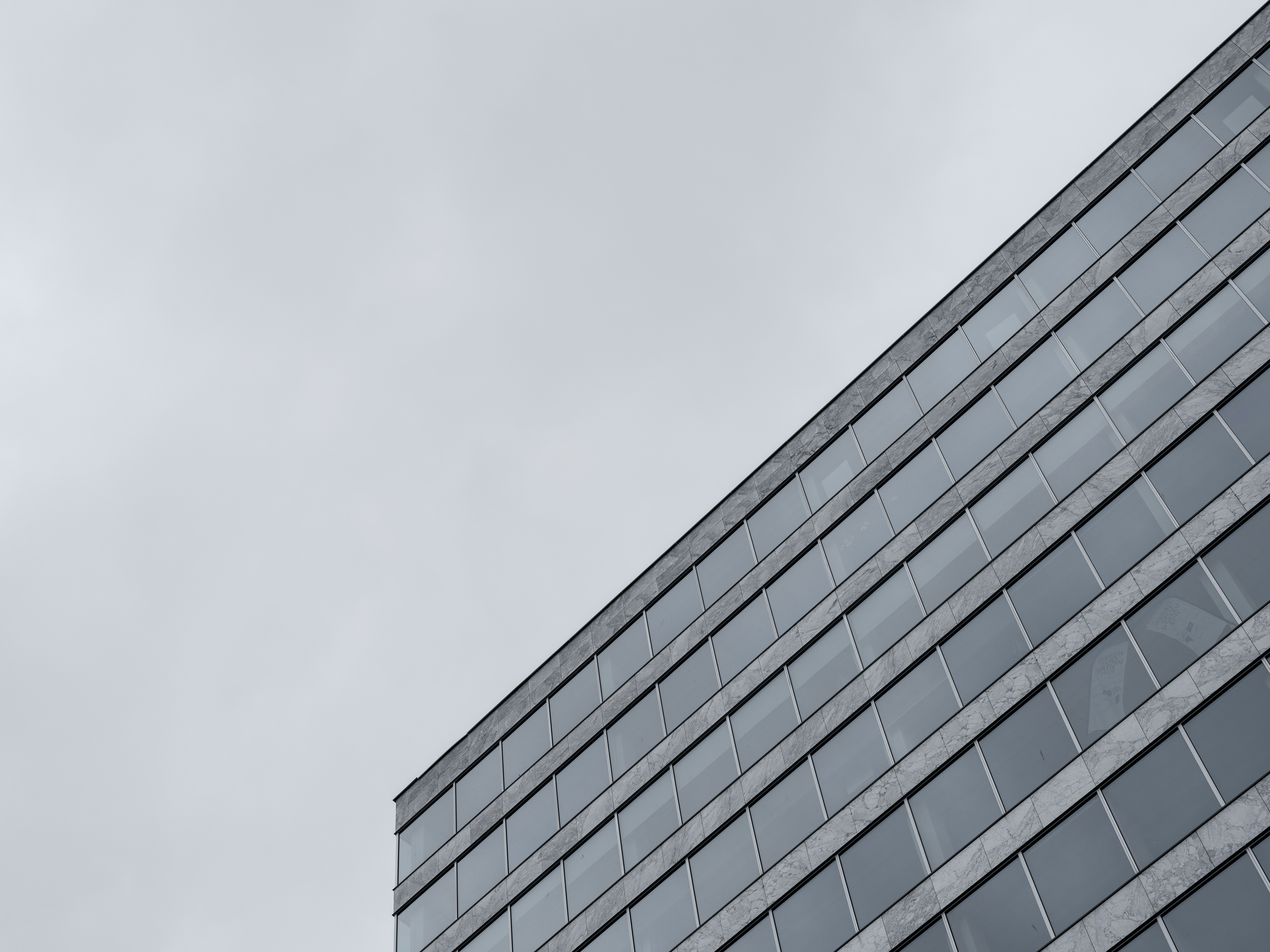 Office Building in Almere Stad | A modern building is framed against cloudy skies.