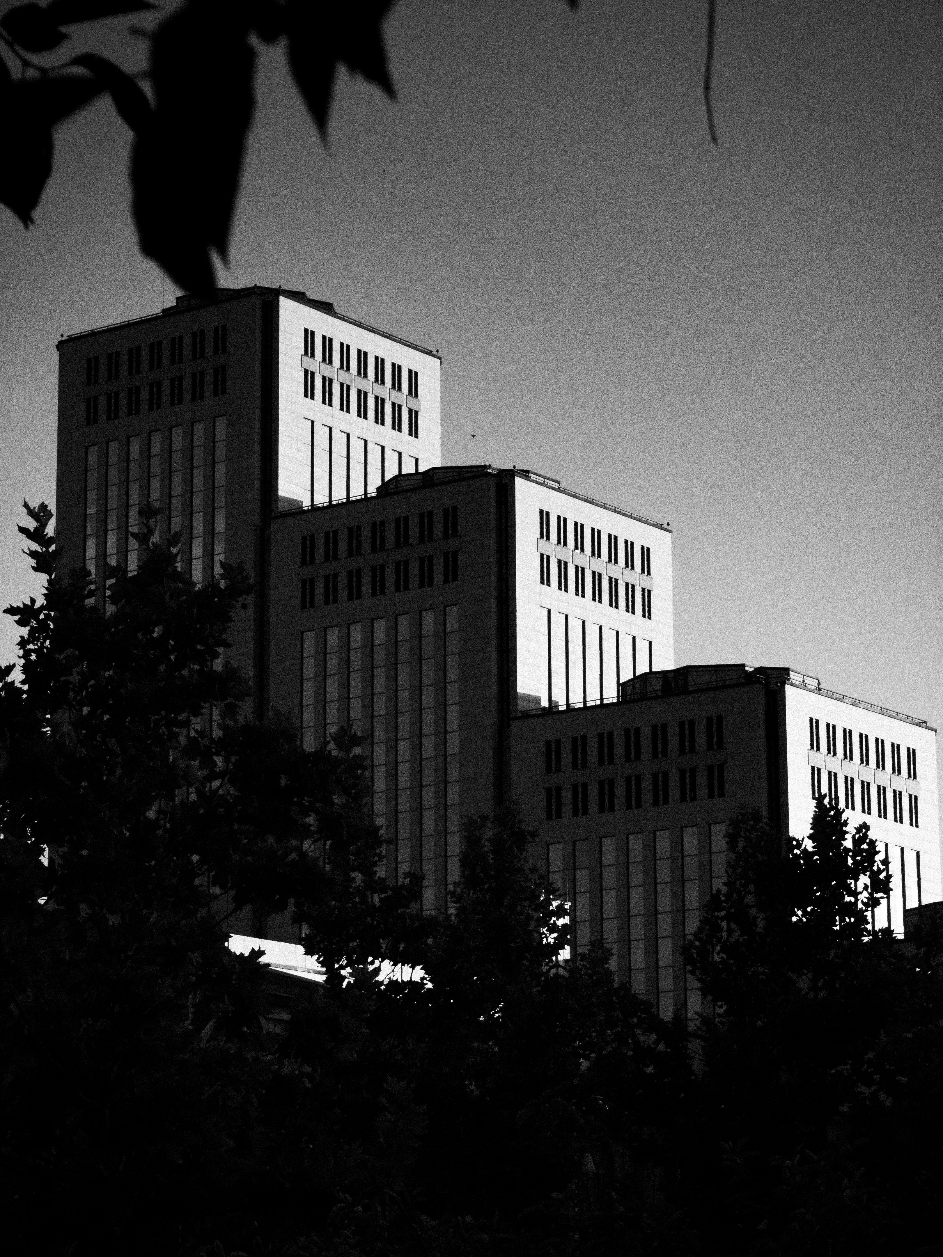 skyscraper complex named Menora in Dnipro. | Buildings are silhouetted against the sky in black and white.