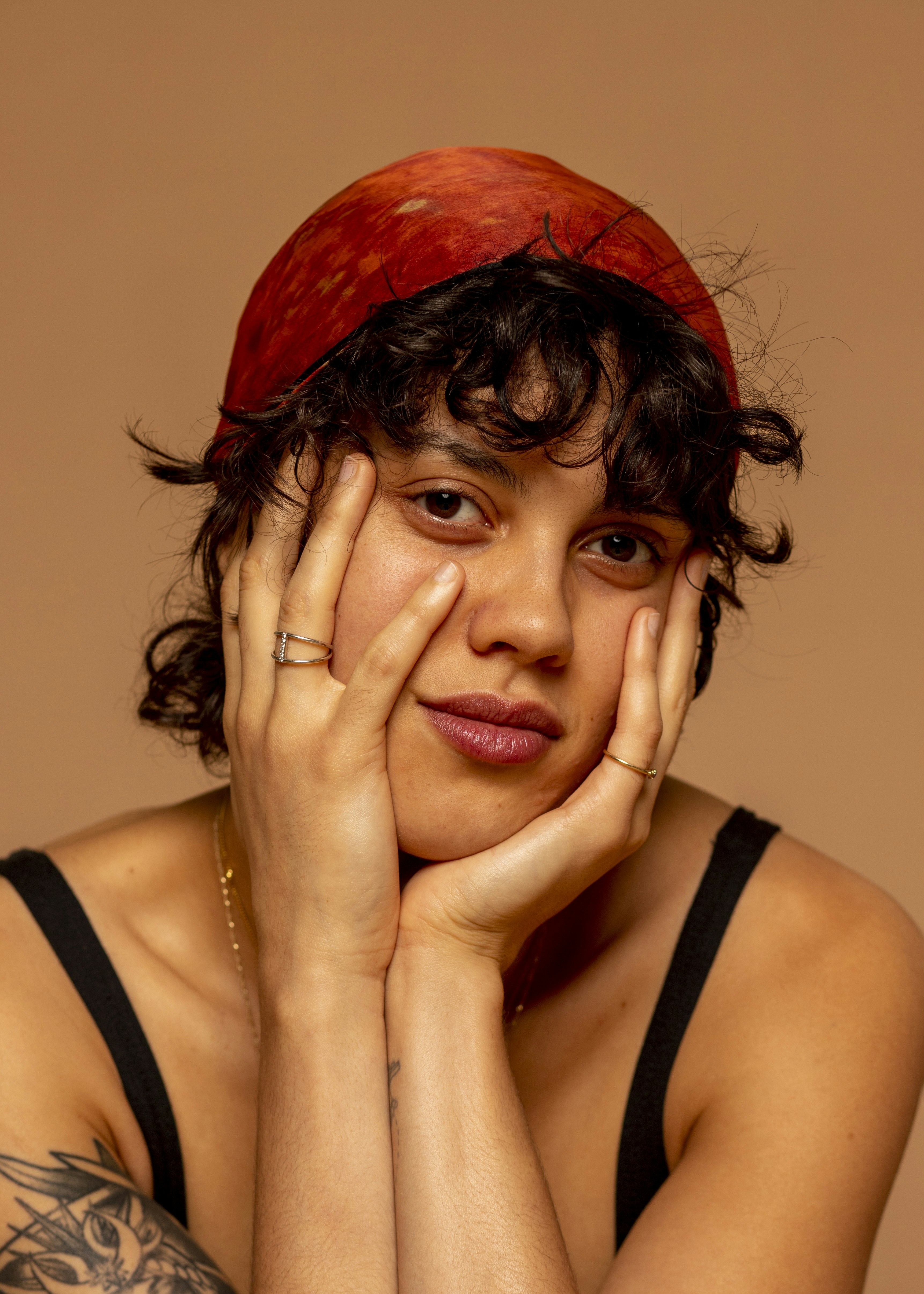 Crimson Quietude: A Portrait with Hands Framing a Warm Gaze