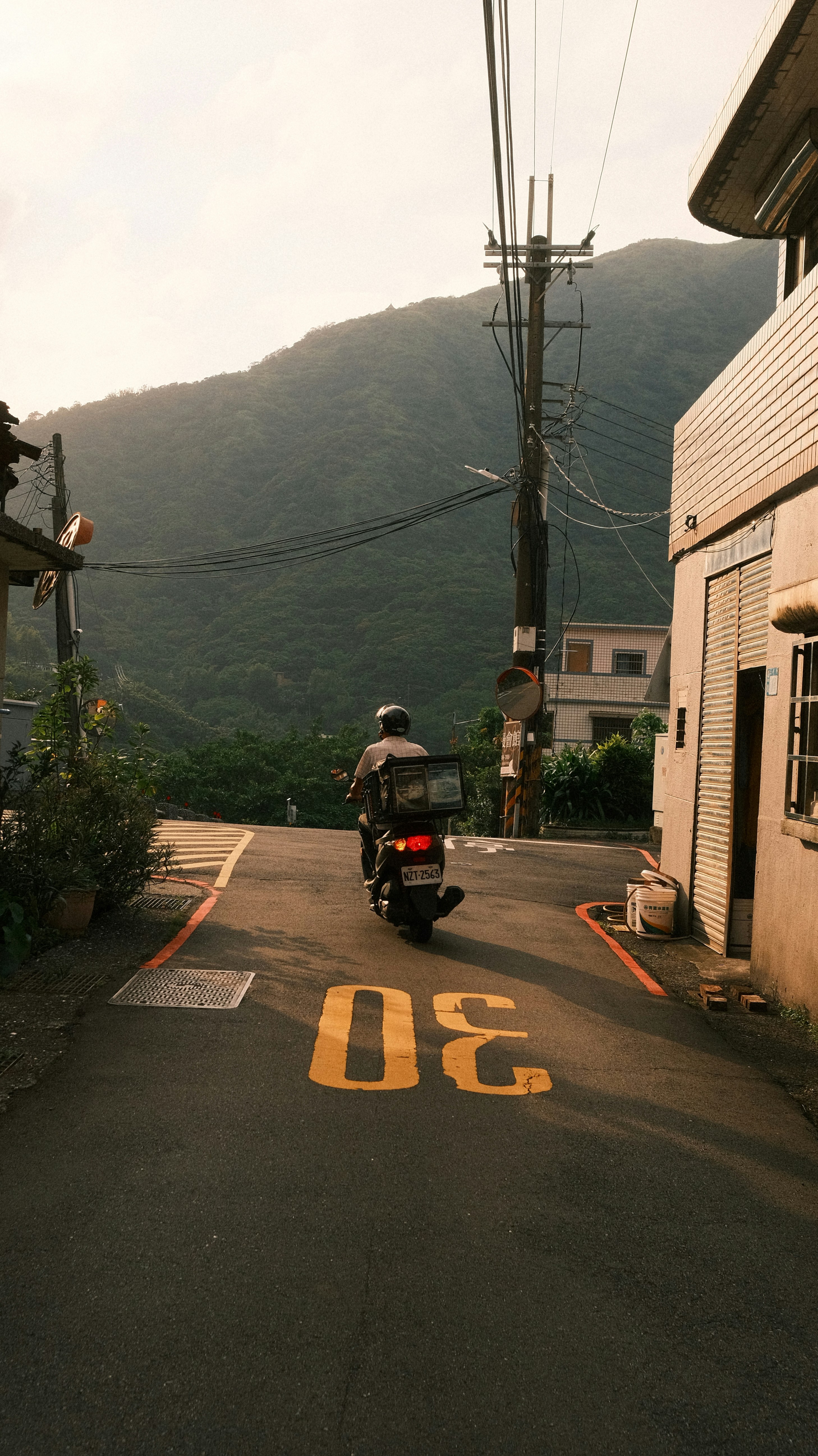 A motorcyclist drives down a scenic road.