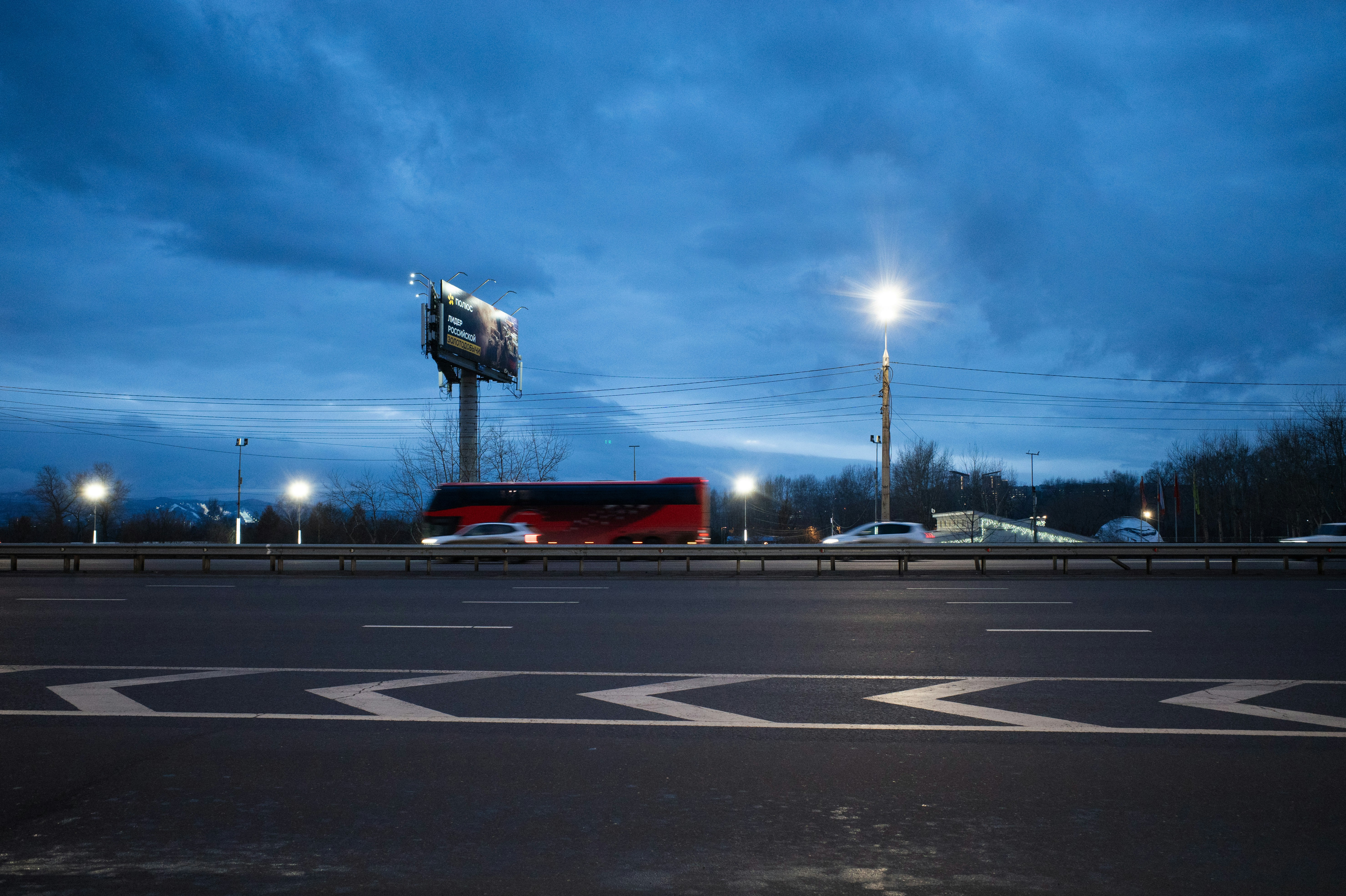Highway traffic at dusk under cloudy skies.