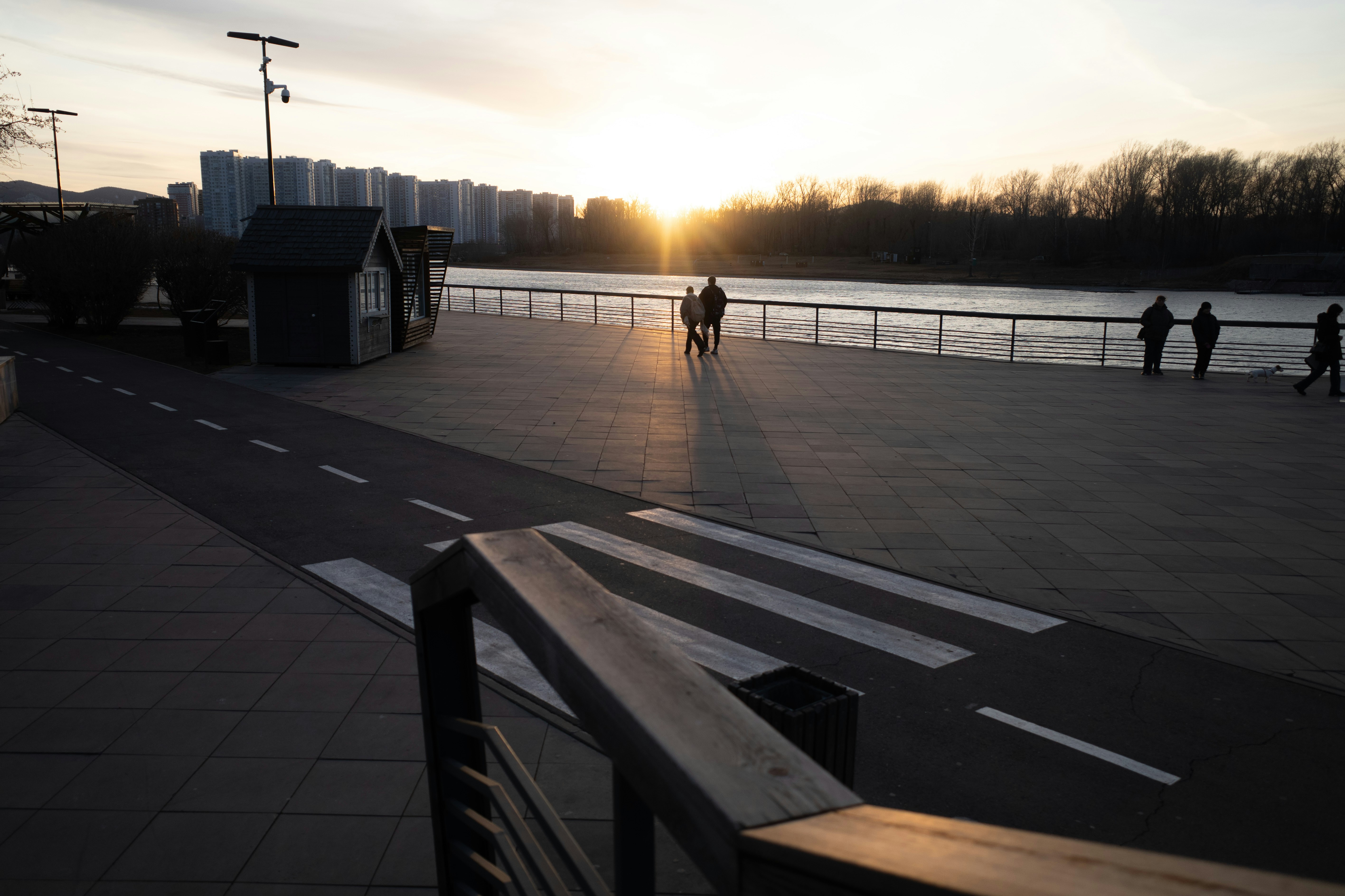 Sunset casts shadows on the waterfront promenade.