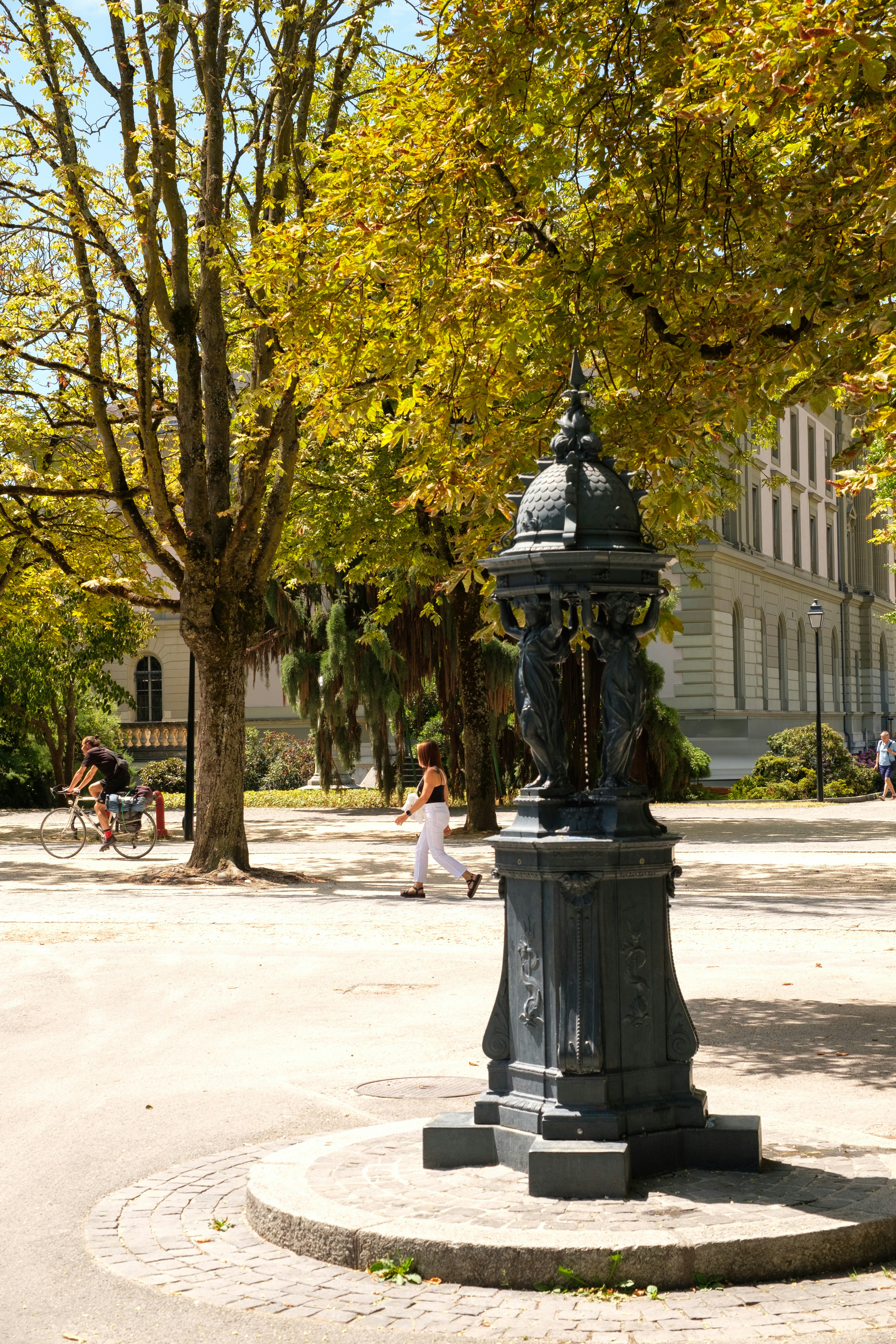 Parc des Bastions | A decorative fountain stands in a sunny park.