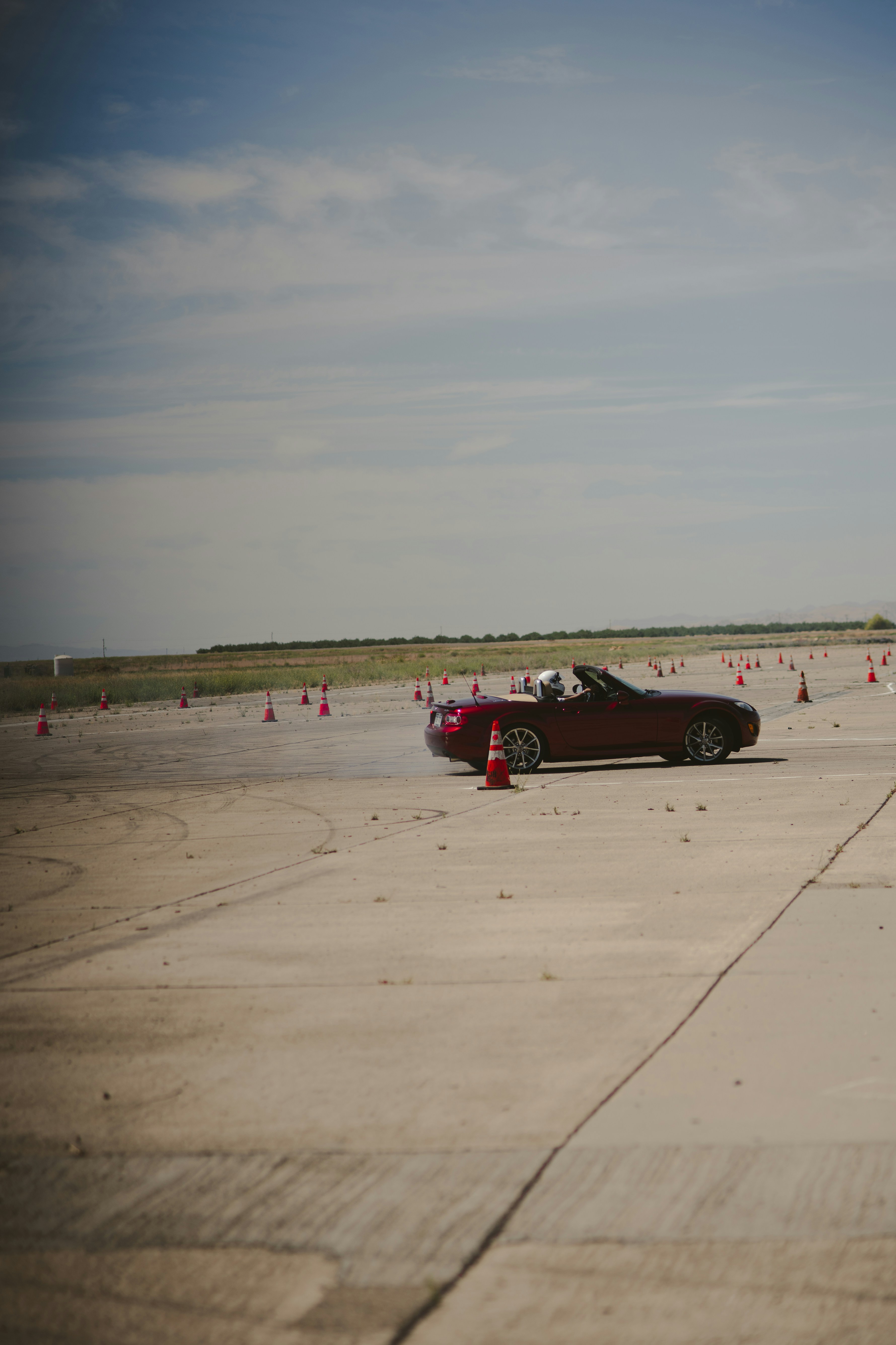A red convertible races on an autocross course.