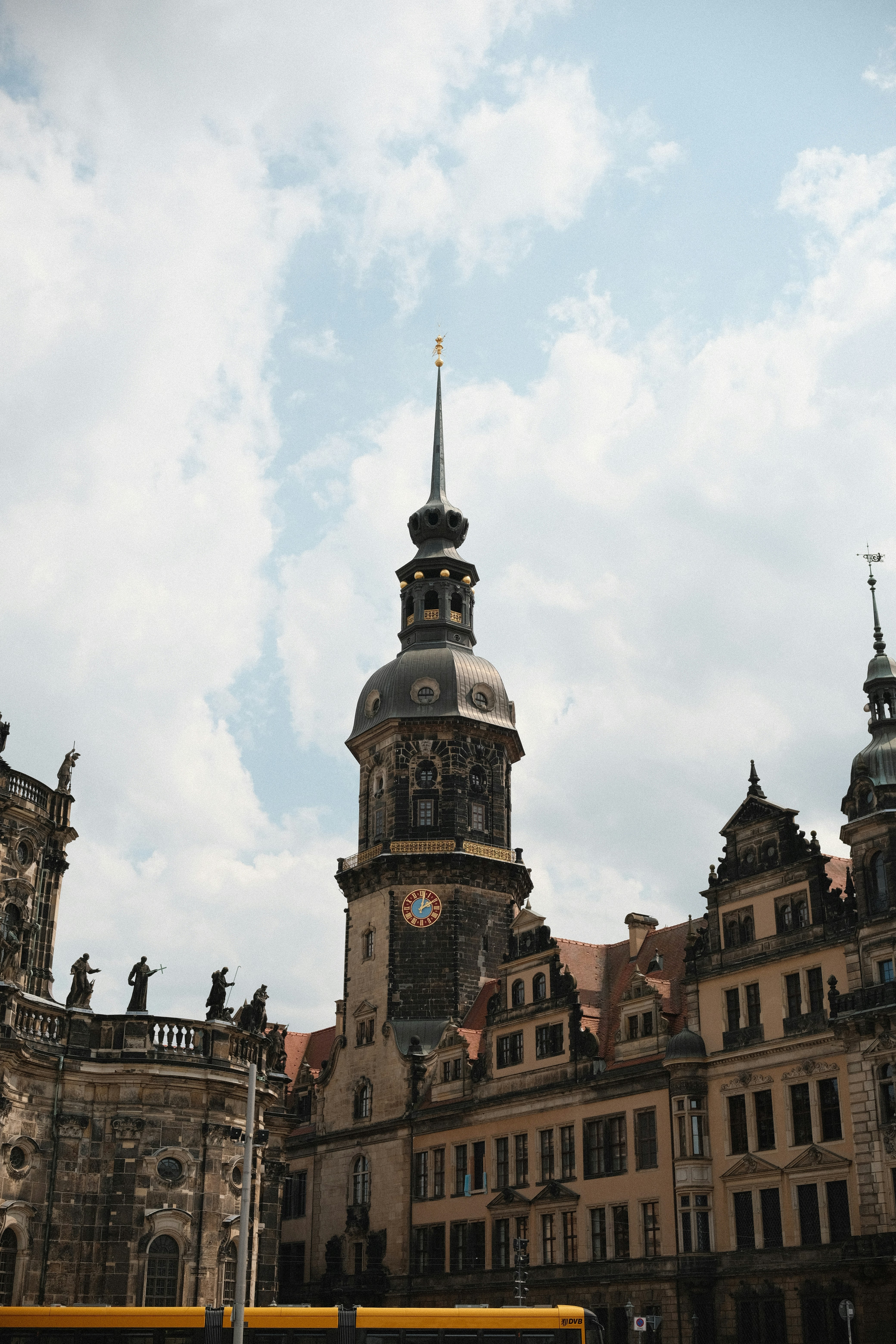 A tall clock tower stands beneath a cloudy sky.