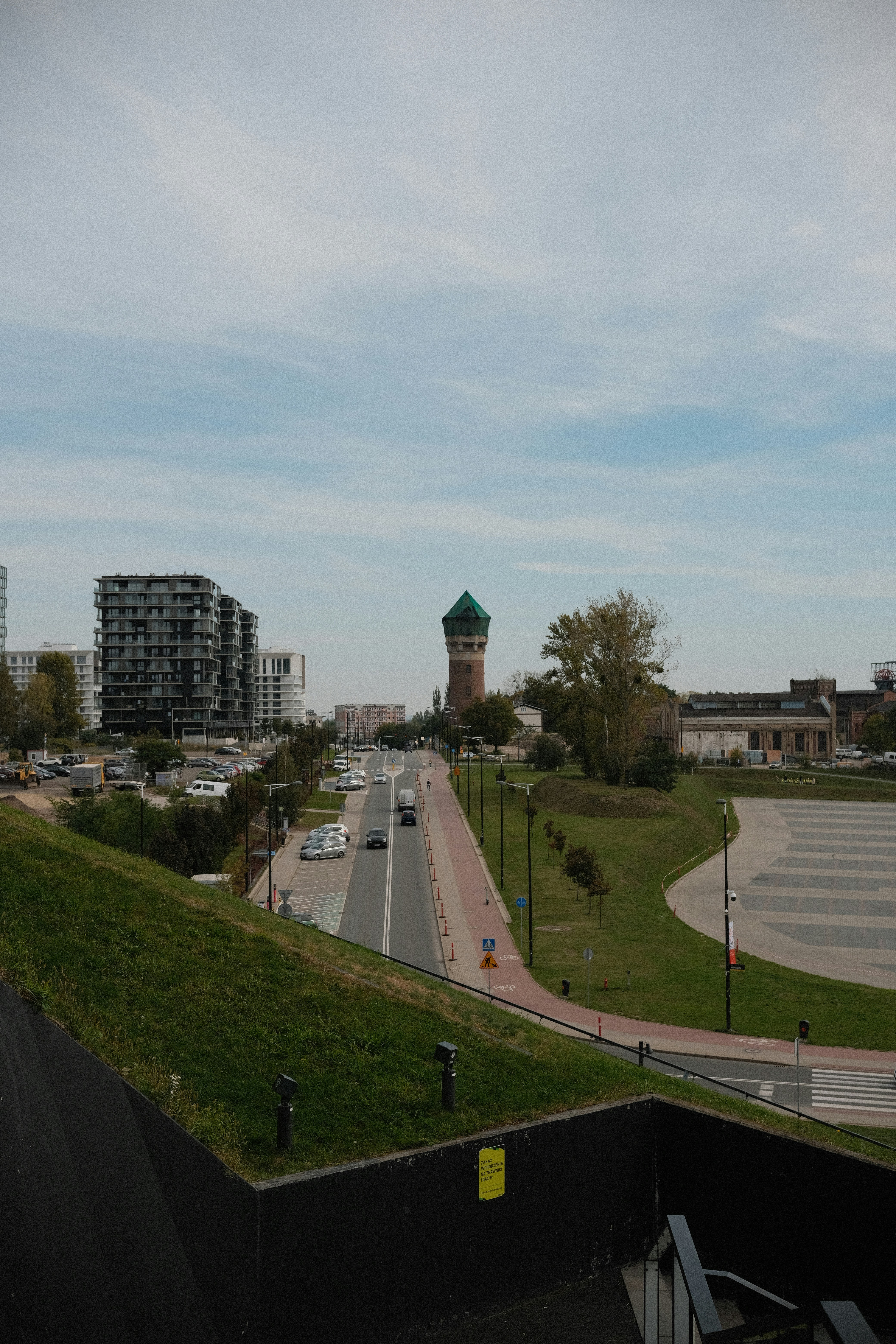 A road leads toward a tower and city buildings.