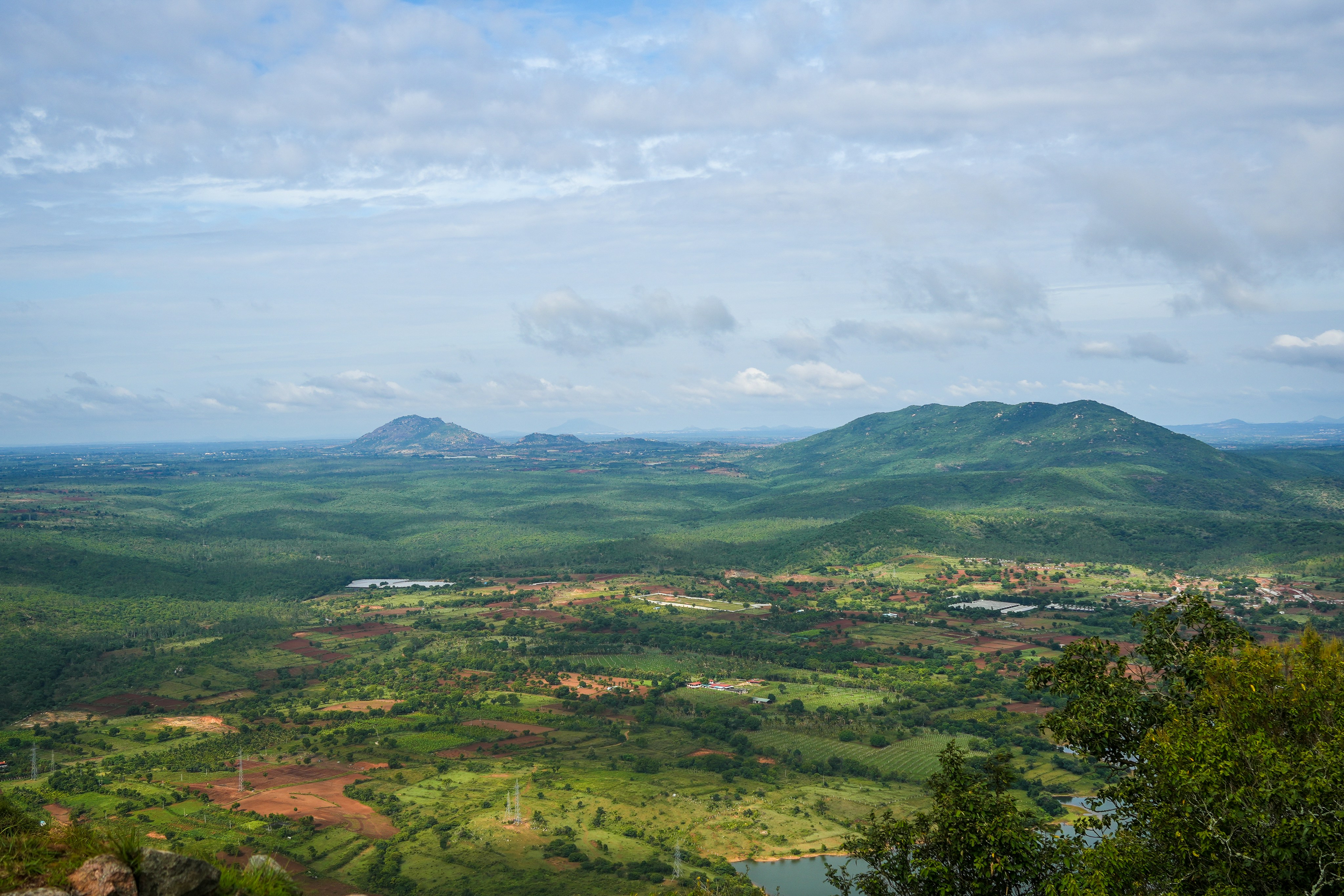 Green landscape with hills and cloudy sky.