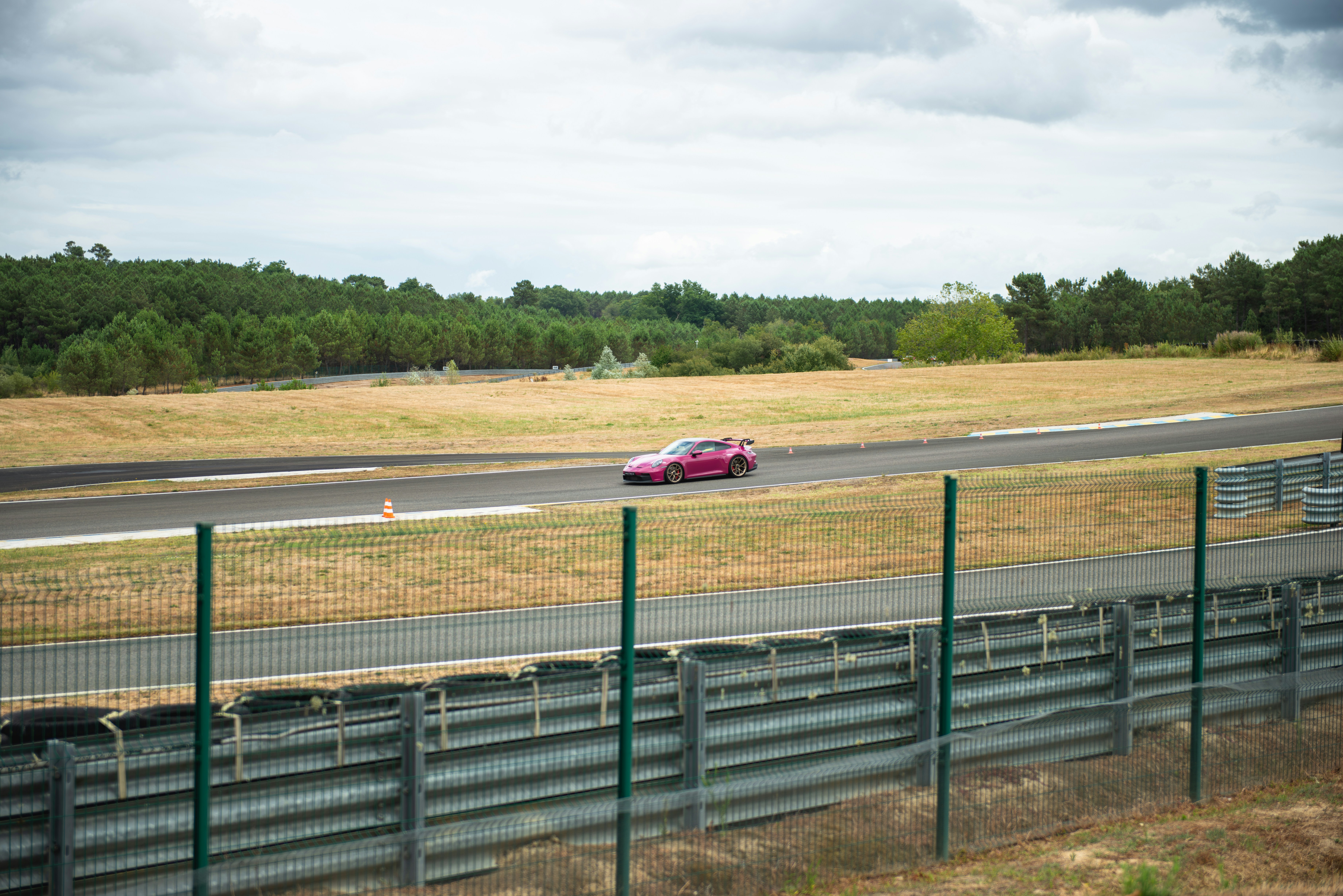 A pink car races around a racetrack. photo – Free Car Image on Unsplash