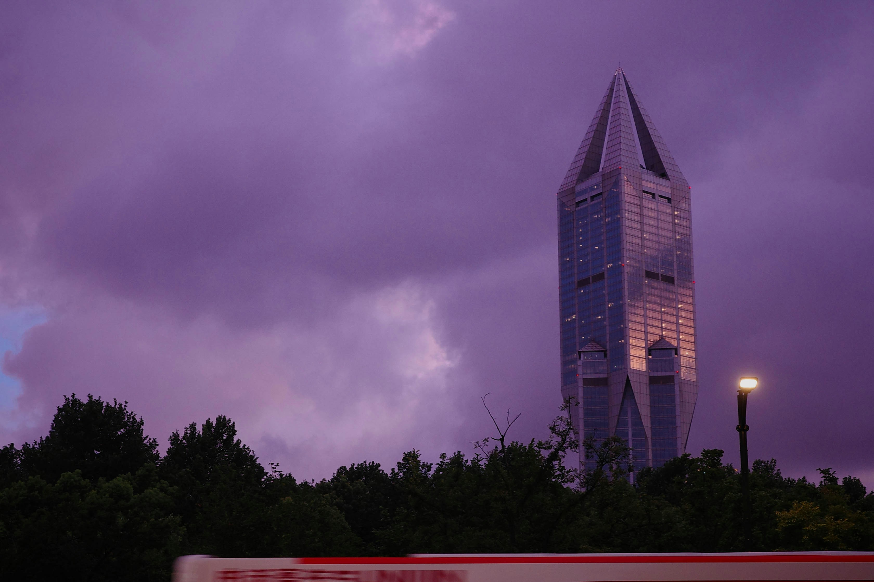 A tall, modern building stands under purple skies.