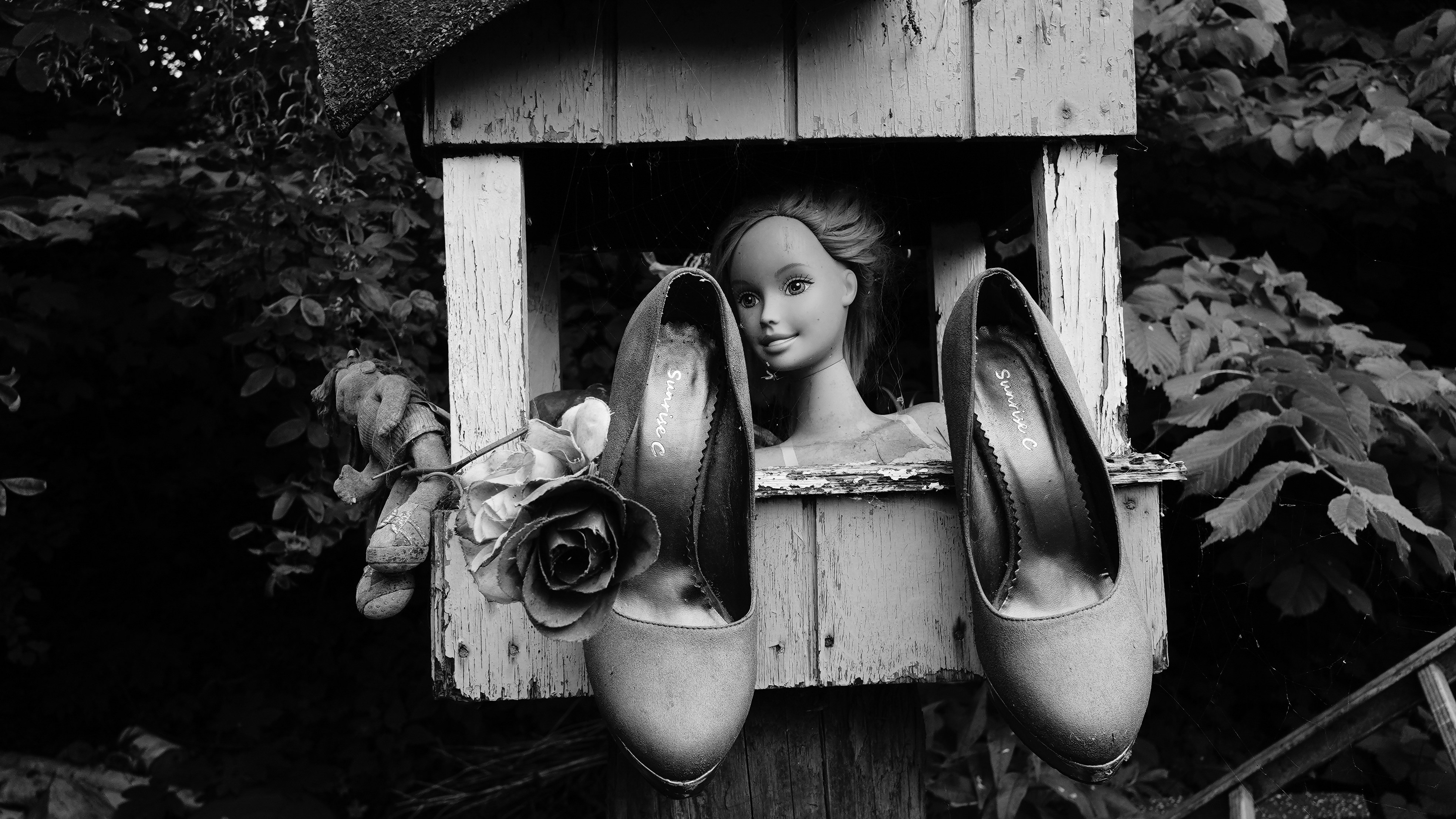 Christiania weird | Doll head and shoes displayed in a birdhouse.