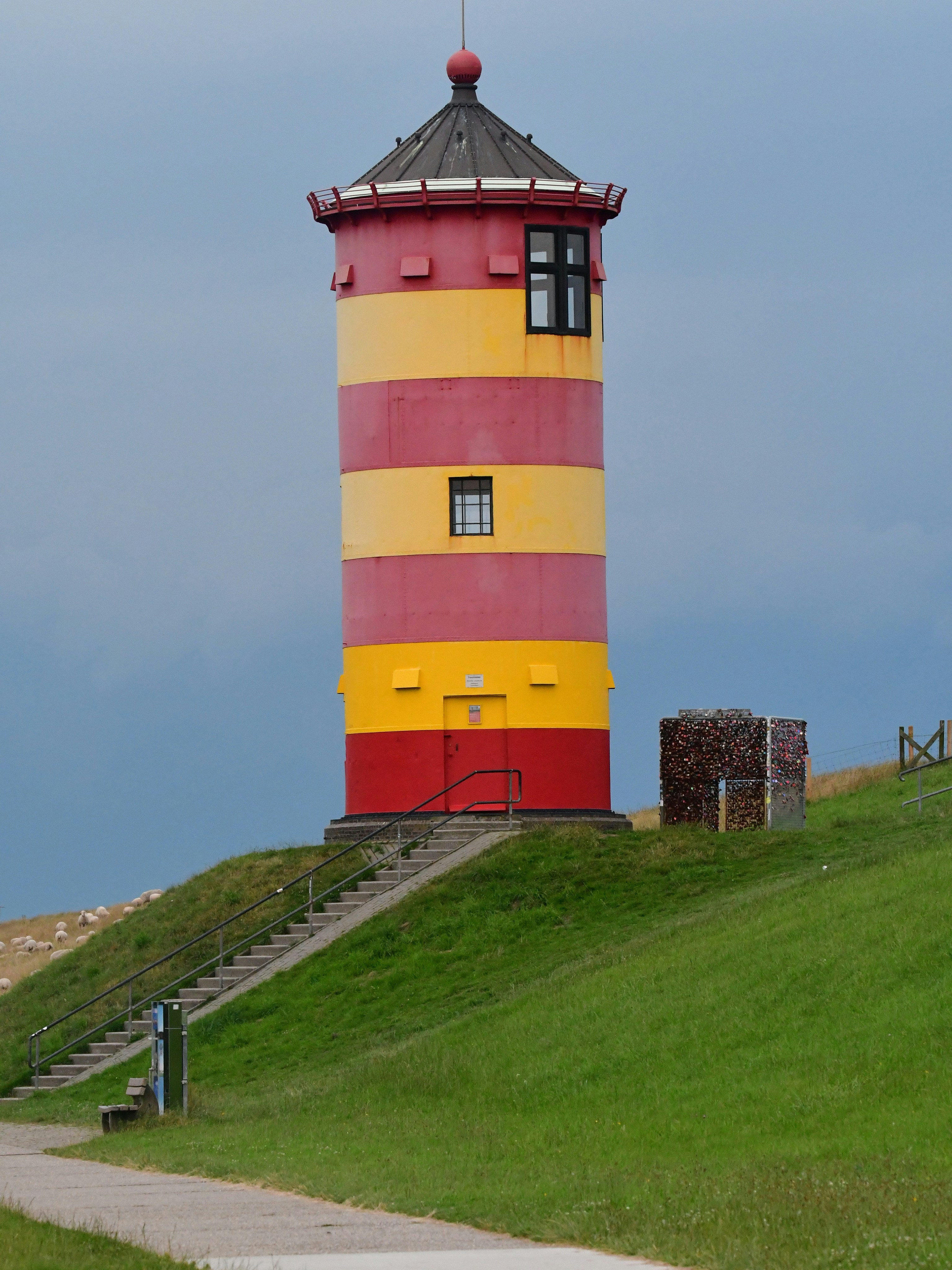 A colorful lighthouse stands tall on a grassy hill. photo – Free ...