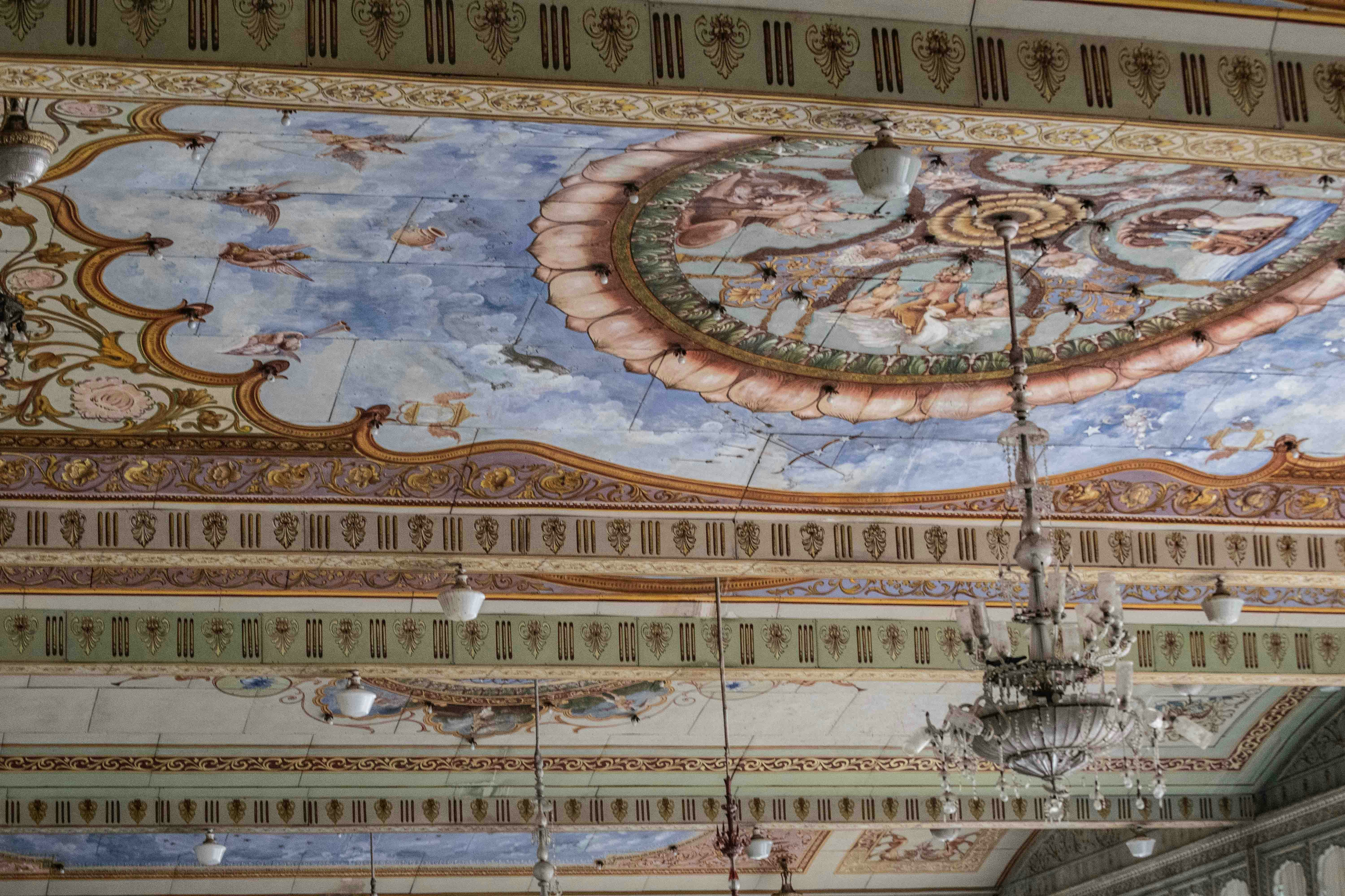 Intricate painted ceiling with chandelier.