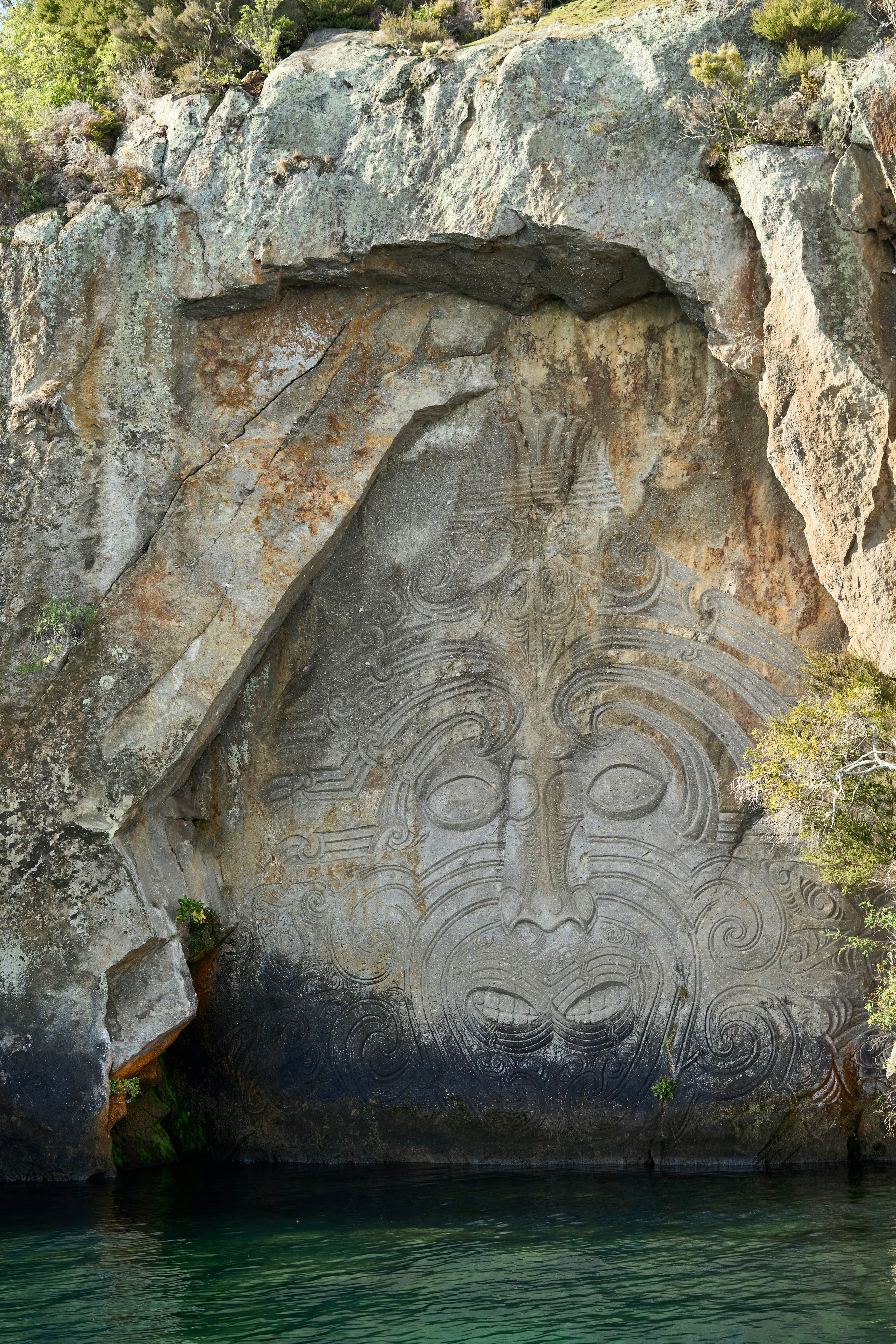 A carving of a face is etched into the cliff.