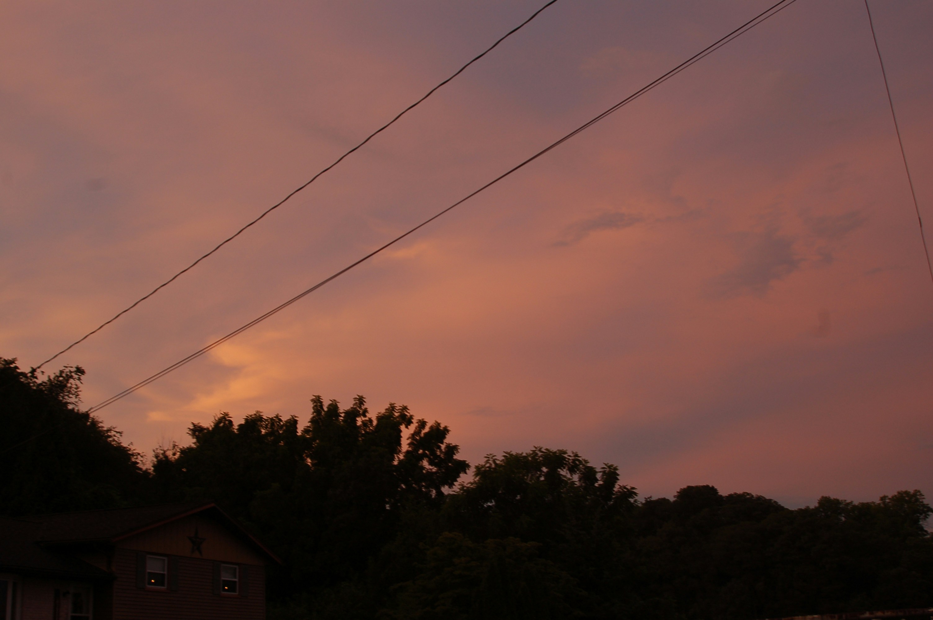 Pink and orange sunset with telephone lines.
