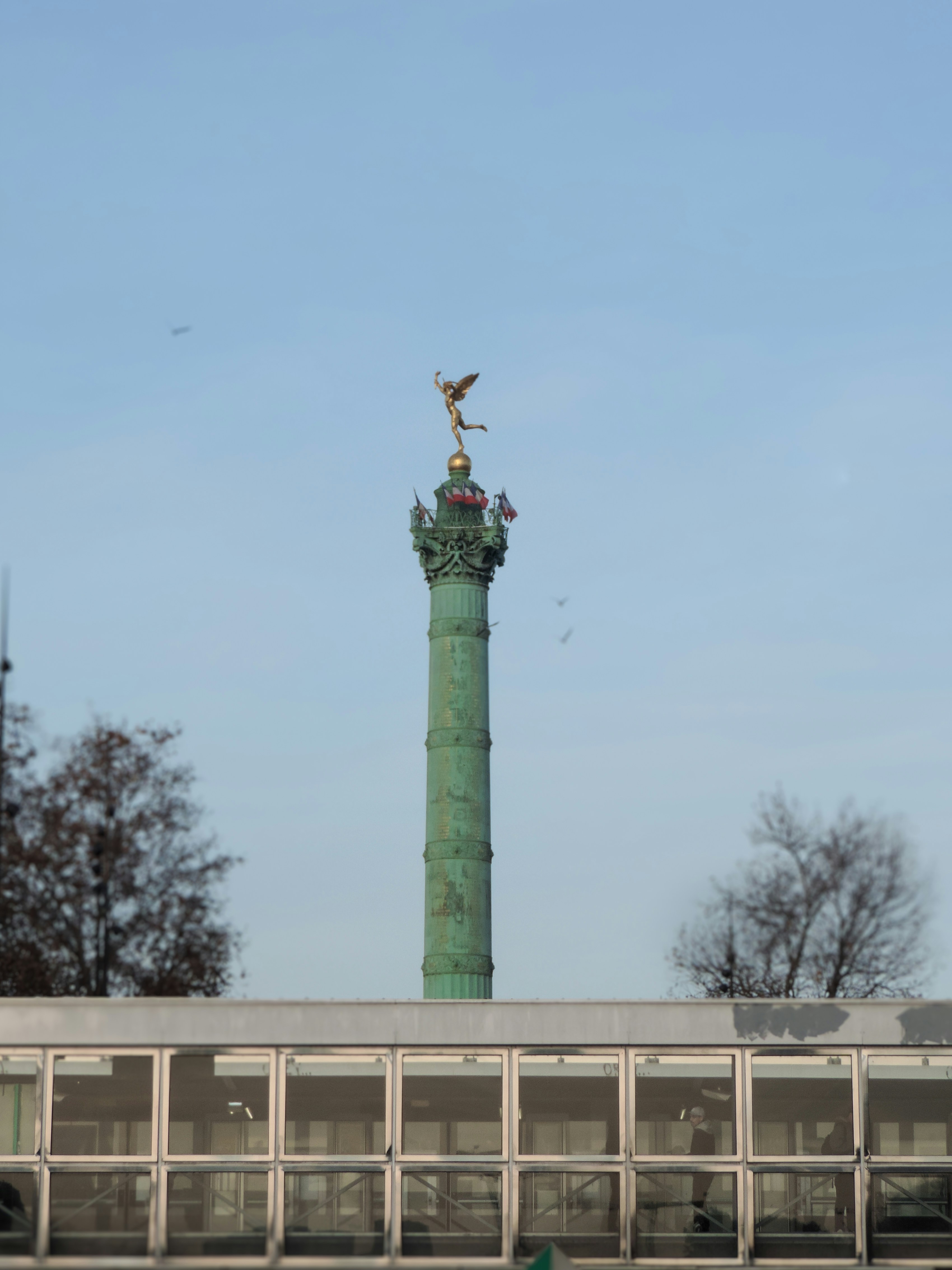 The bastille column rises against a blue sky.