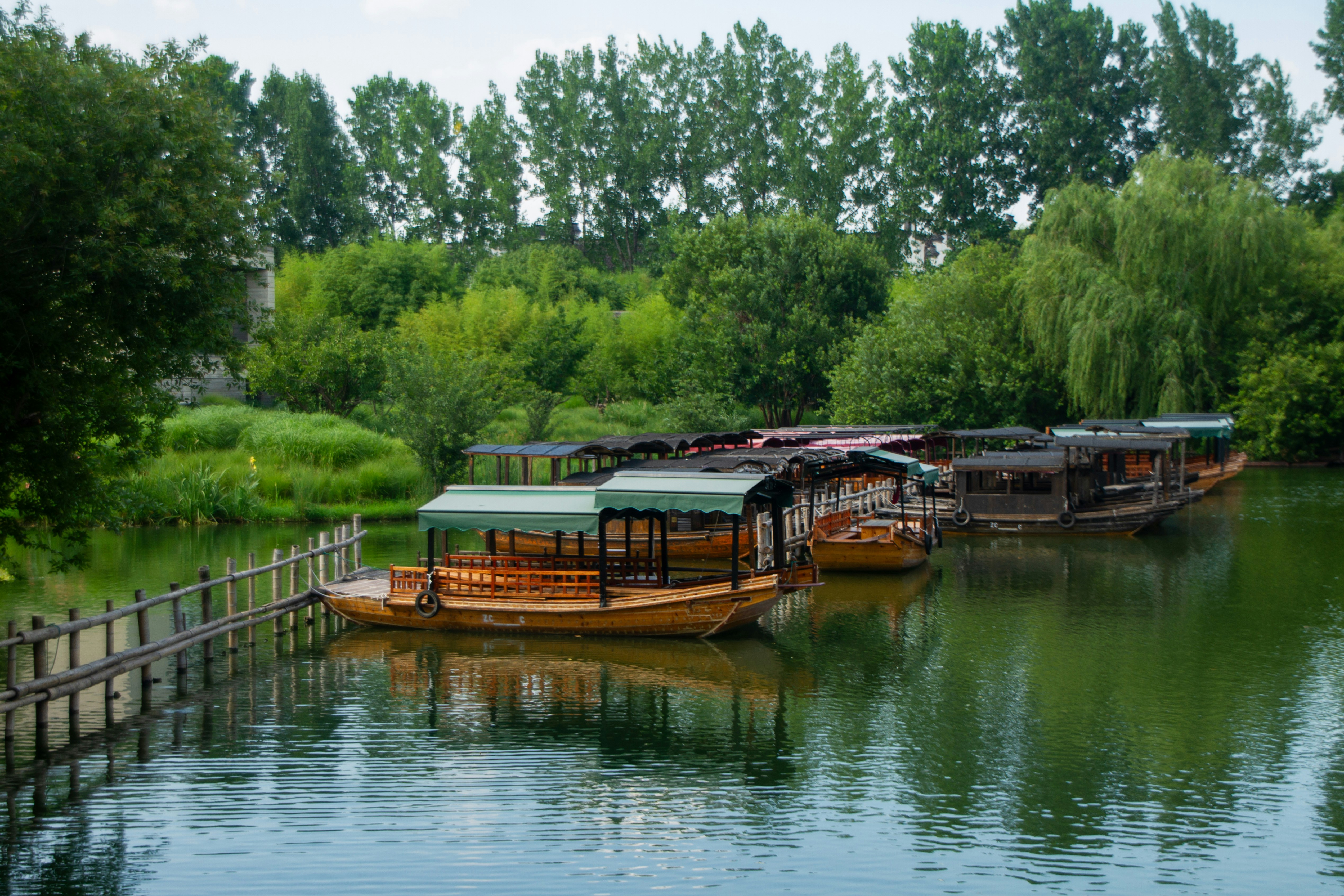 Boats on water. | Boats rest on a serene lake surrounded by lush greenery.