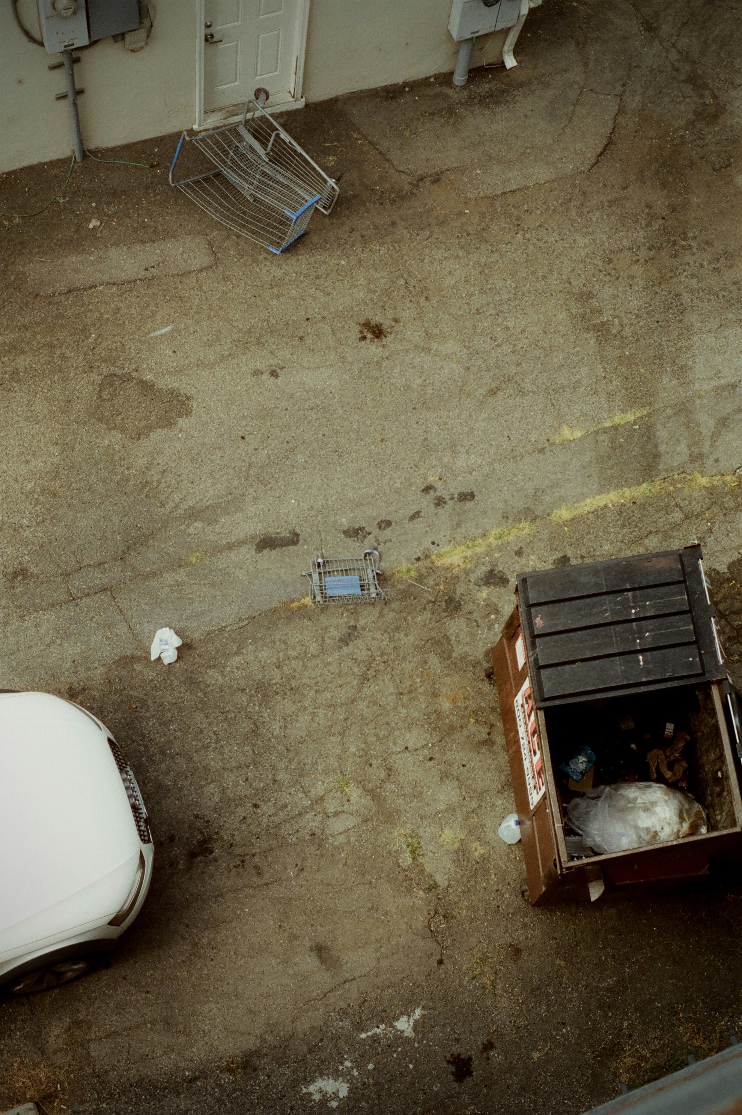 A dirty alleyway features a dumpster and debris. photo – Free Outdoors ...