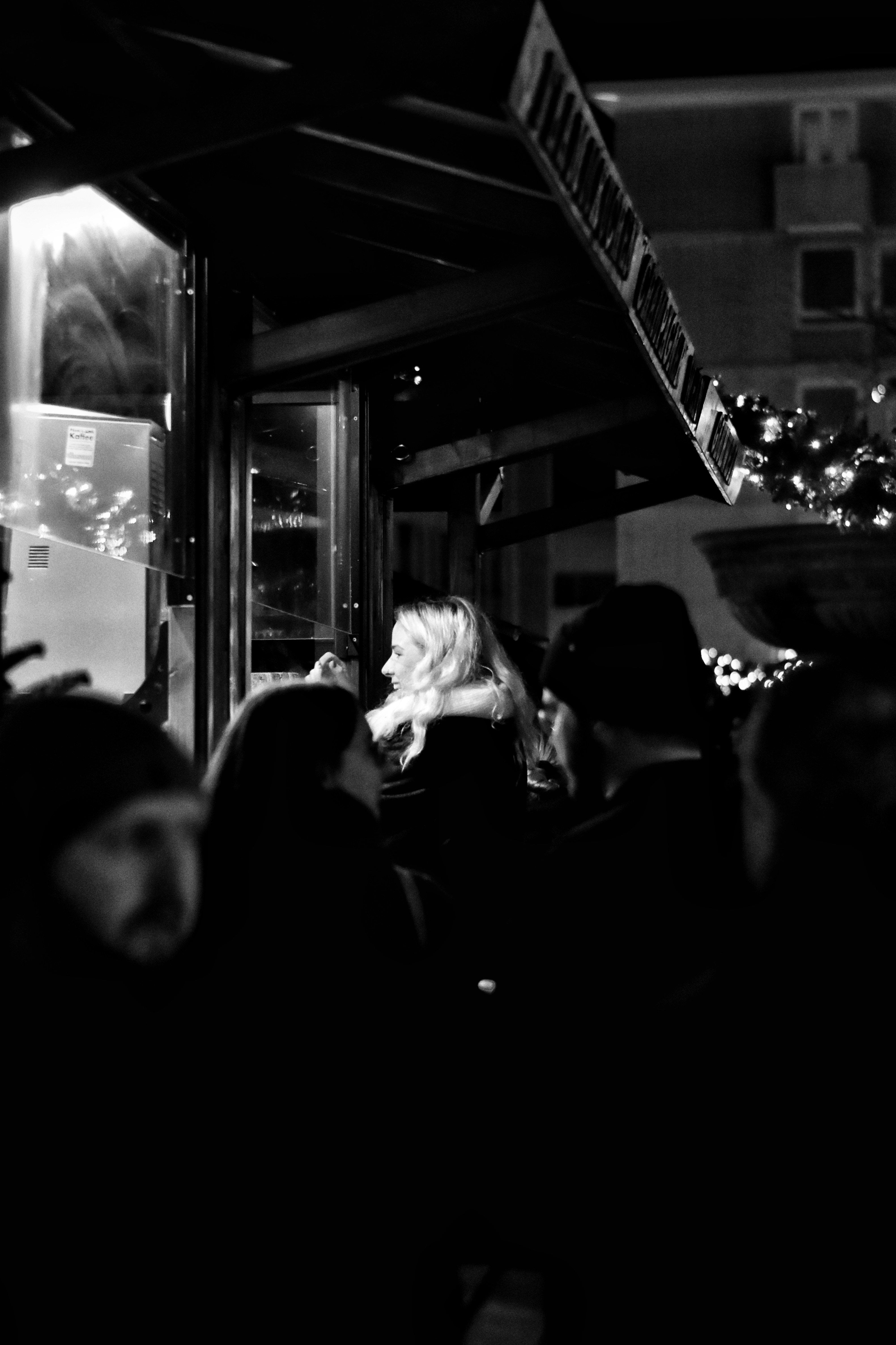 People stand near an outdoor food stall.