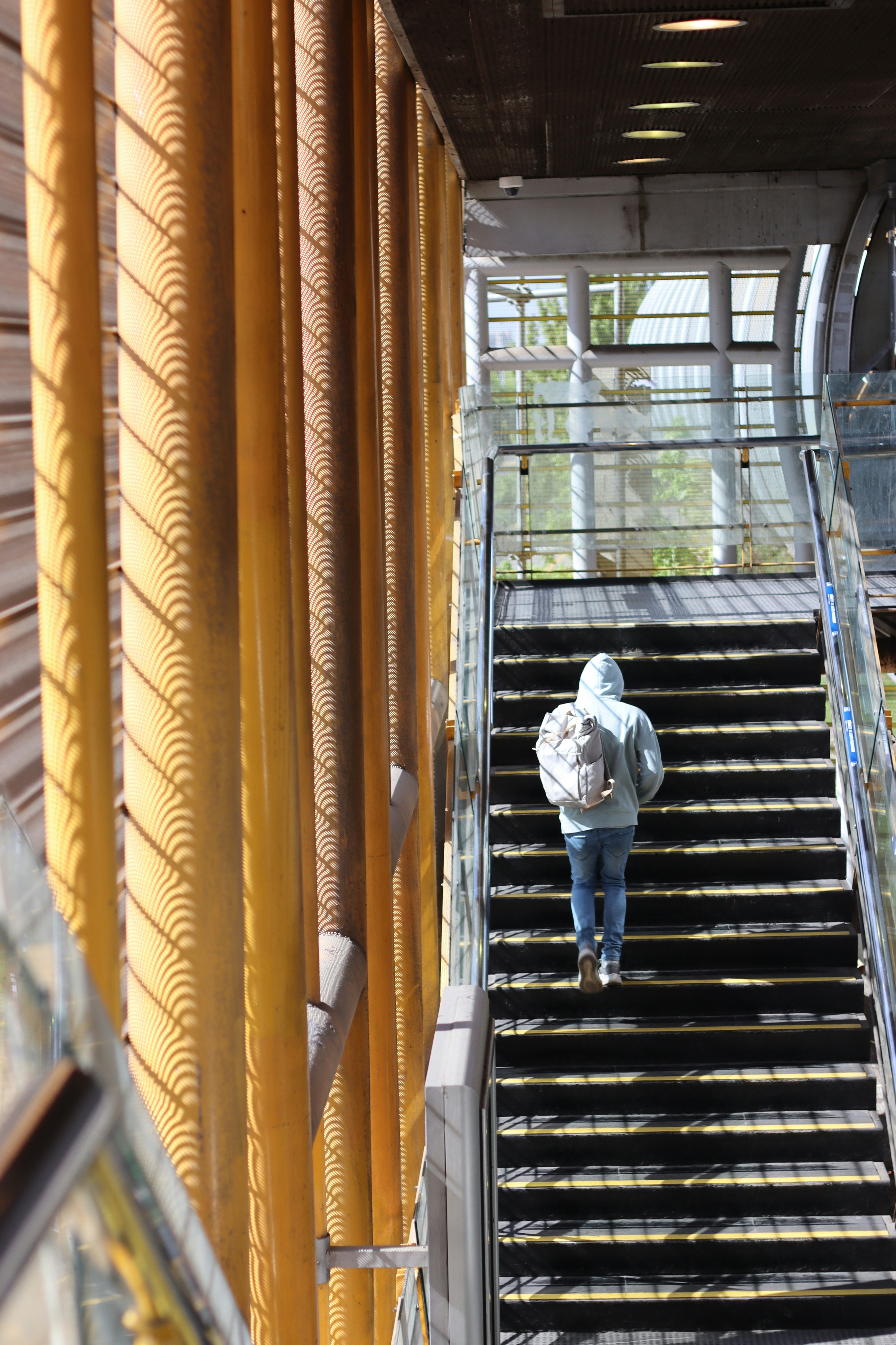 Traveler in a Sunlit Architectural Corridor