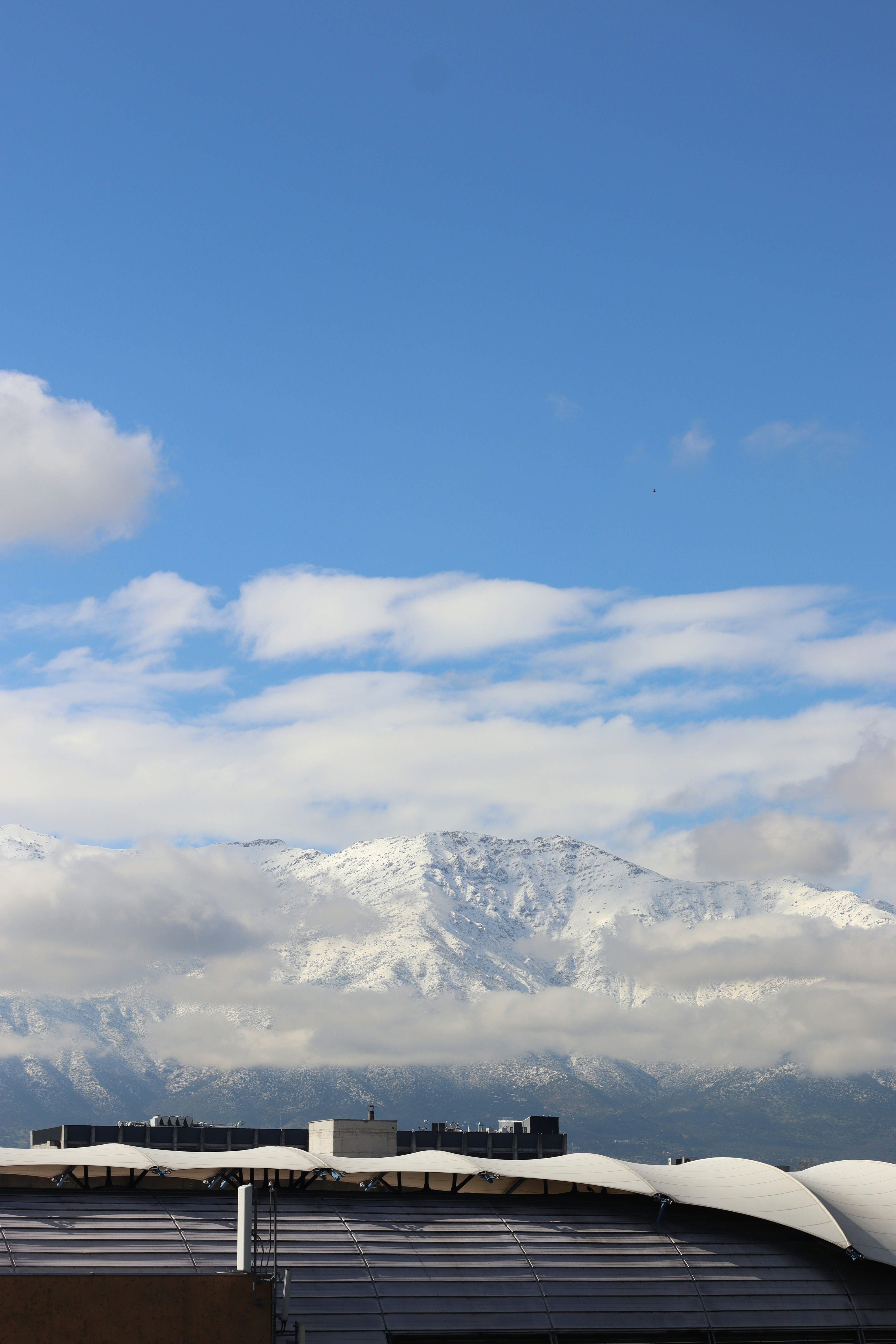 Snowy mountain peaks stand under a bright blue sky.