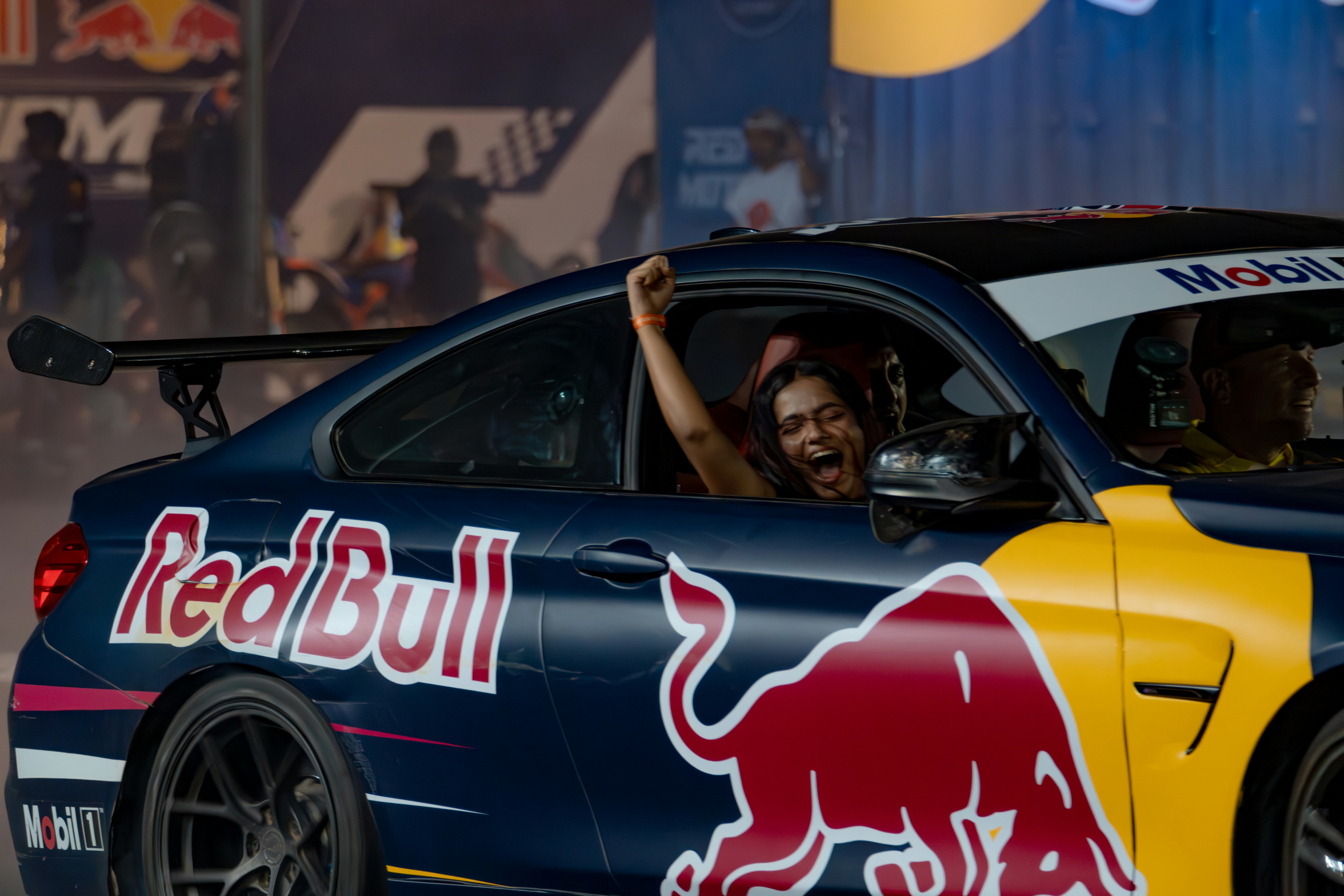 A racer celebrates victory in their red bull car. photo – Free Car ...